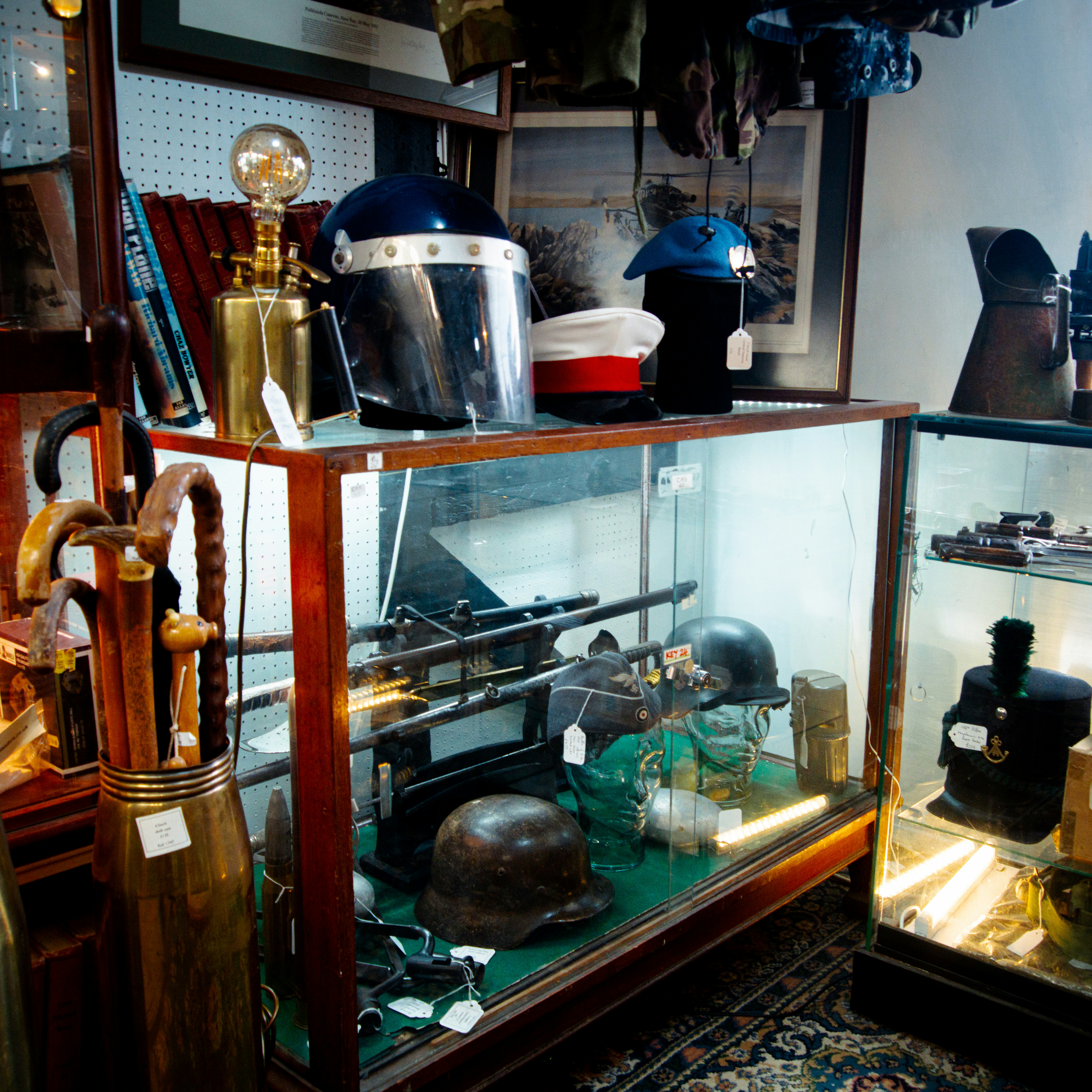 Glinting relics: a glass case of vintage helmets and hardware