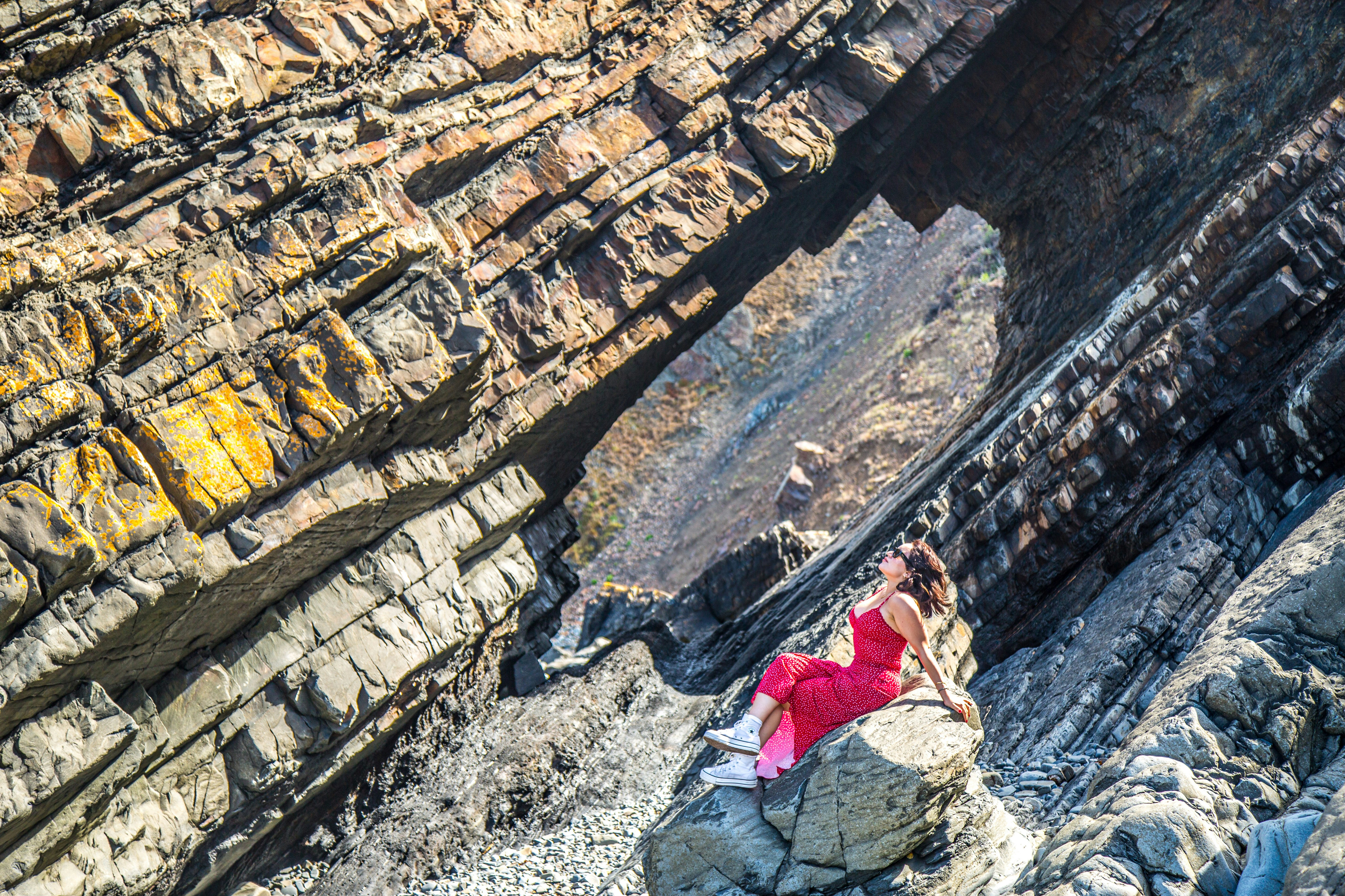 Giant Seashore Veil: A Woman in Pink on Jagged Rock