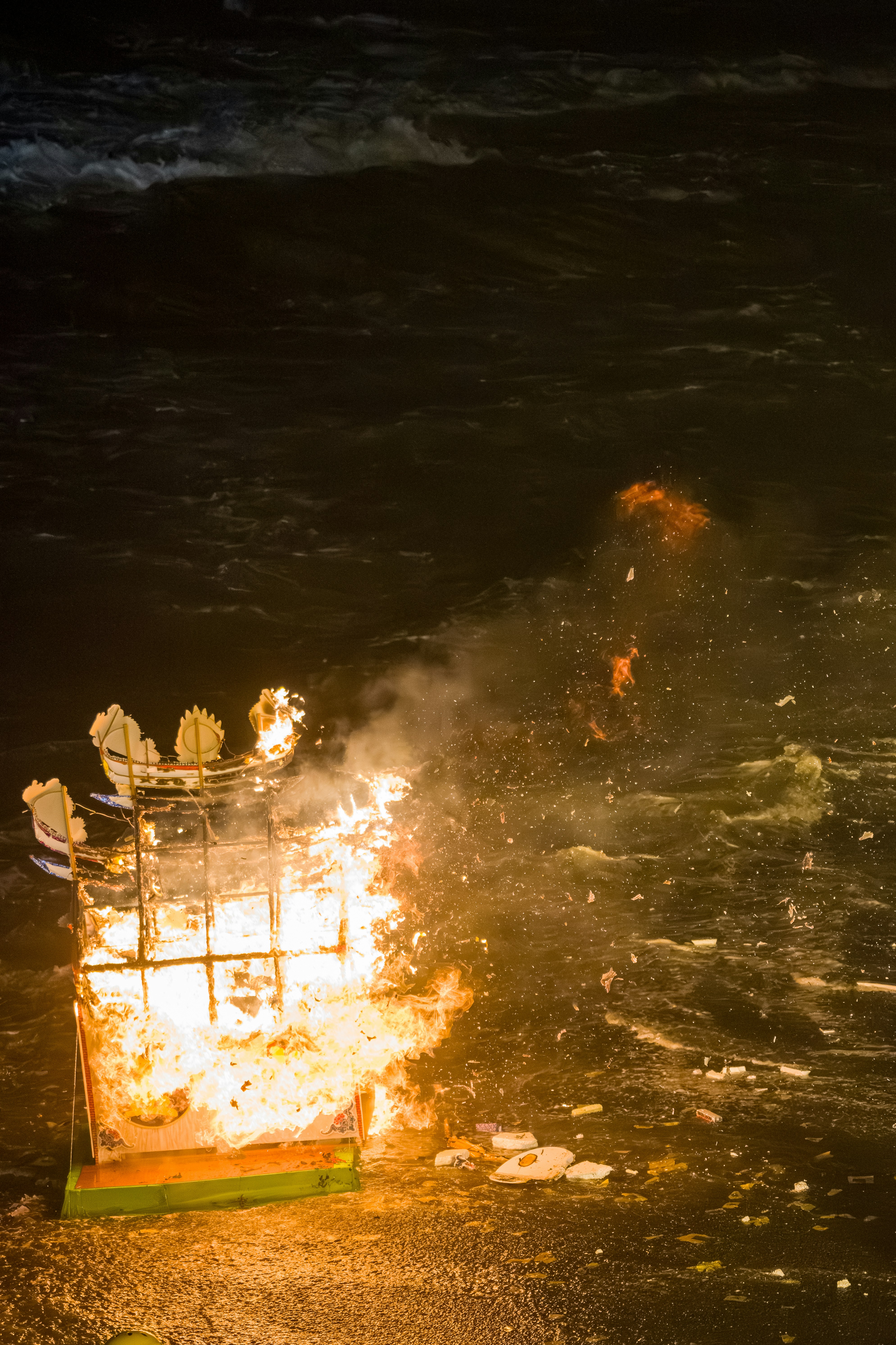 Inferno on the Pier: Flaming Figure Erupts Against Dark Tide