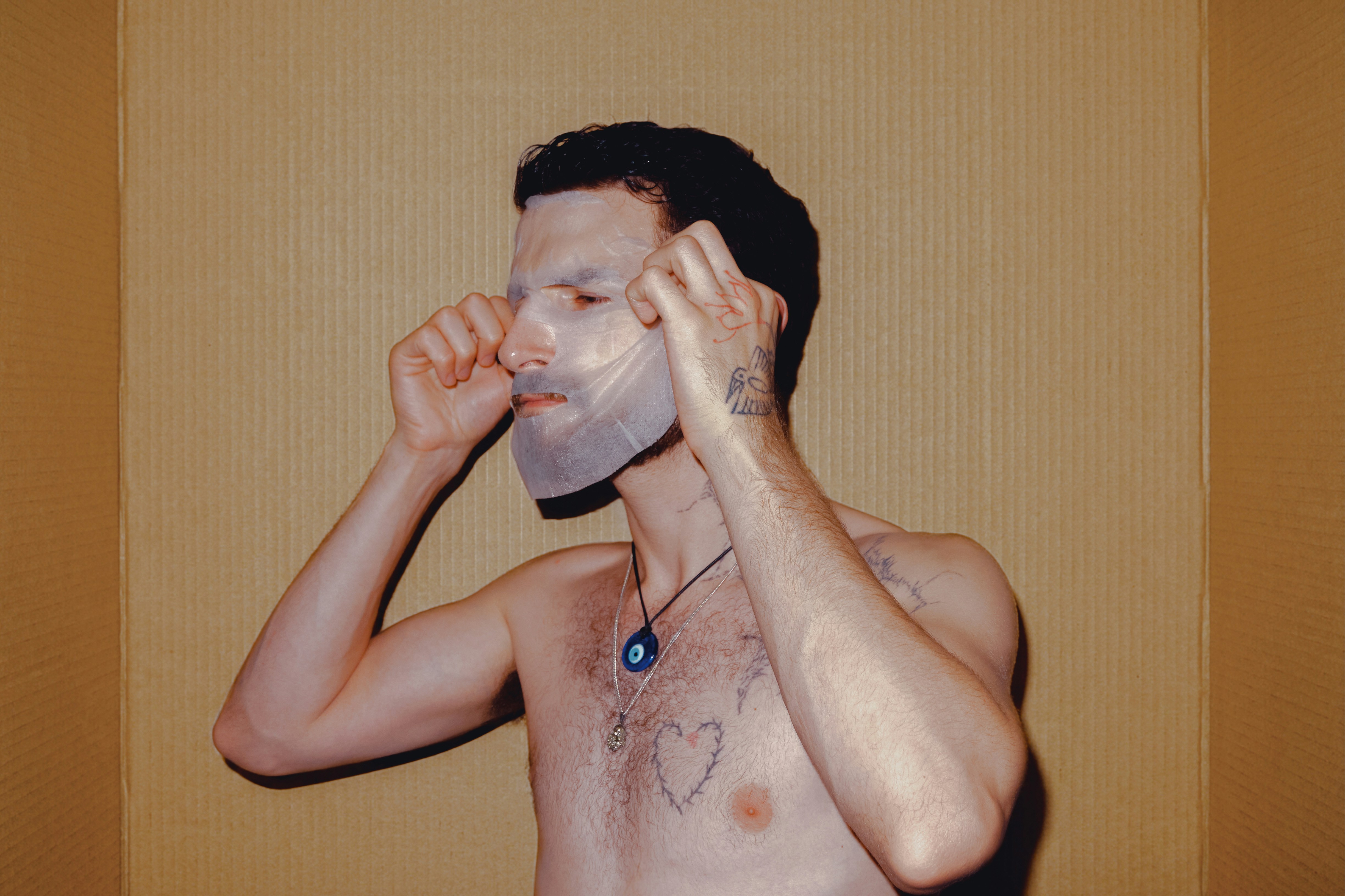 Mask of Mystery: A Bare-Chested Moment in a Cardboard Room