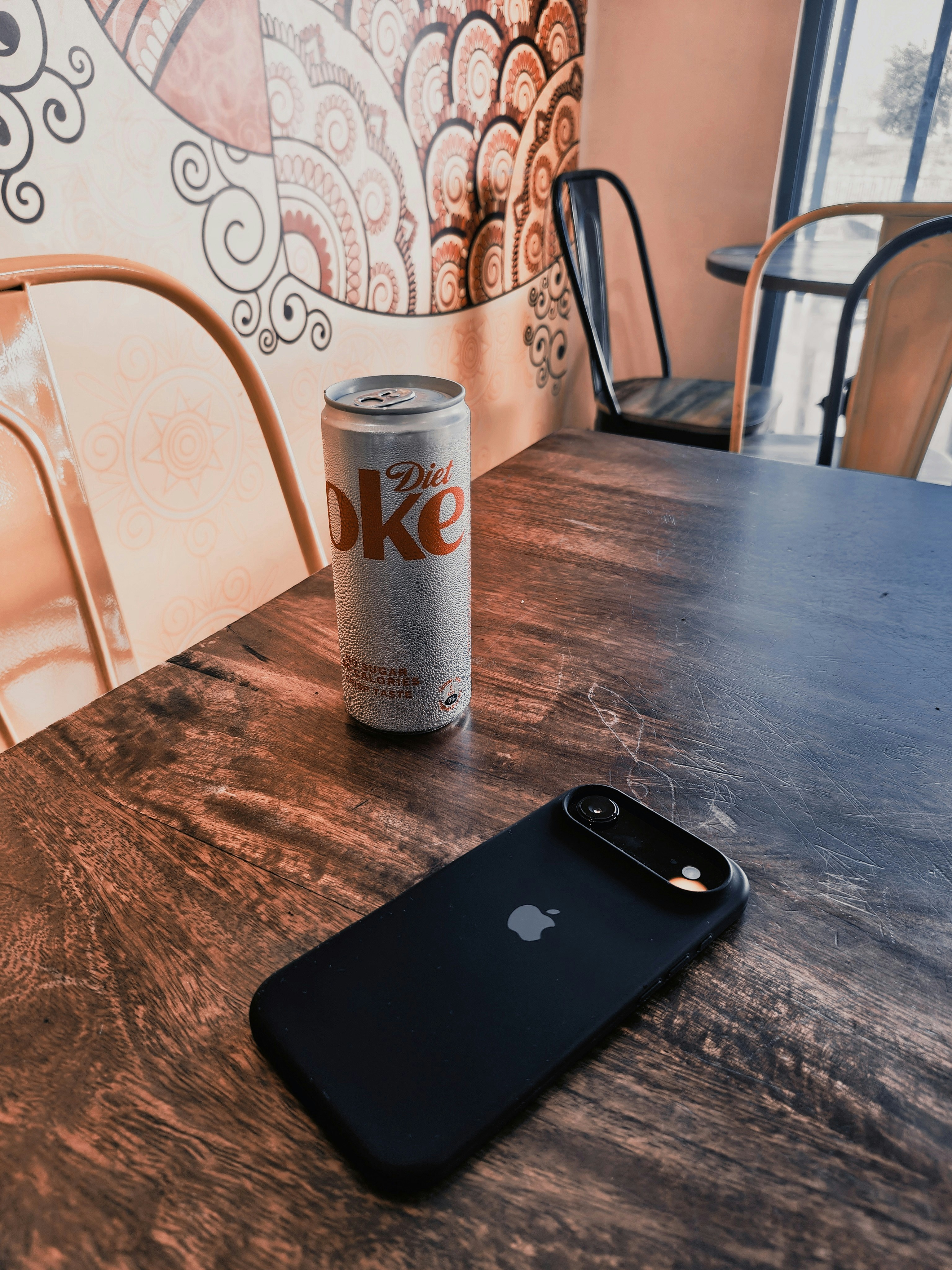 Café Quiet: Soda Can and Phone Rest on a Wooden Table