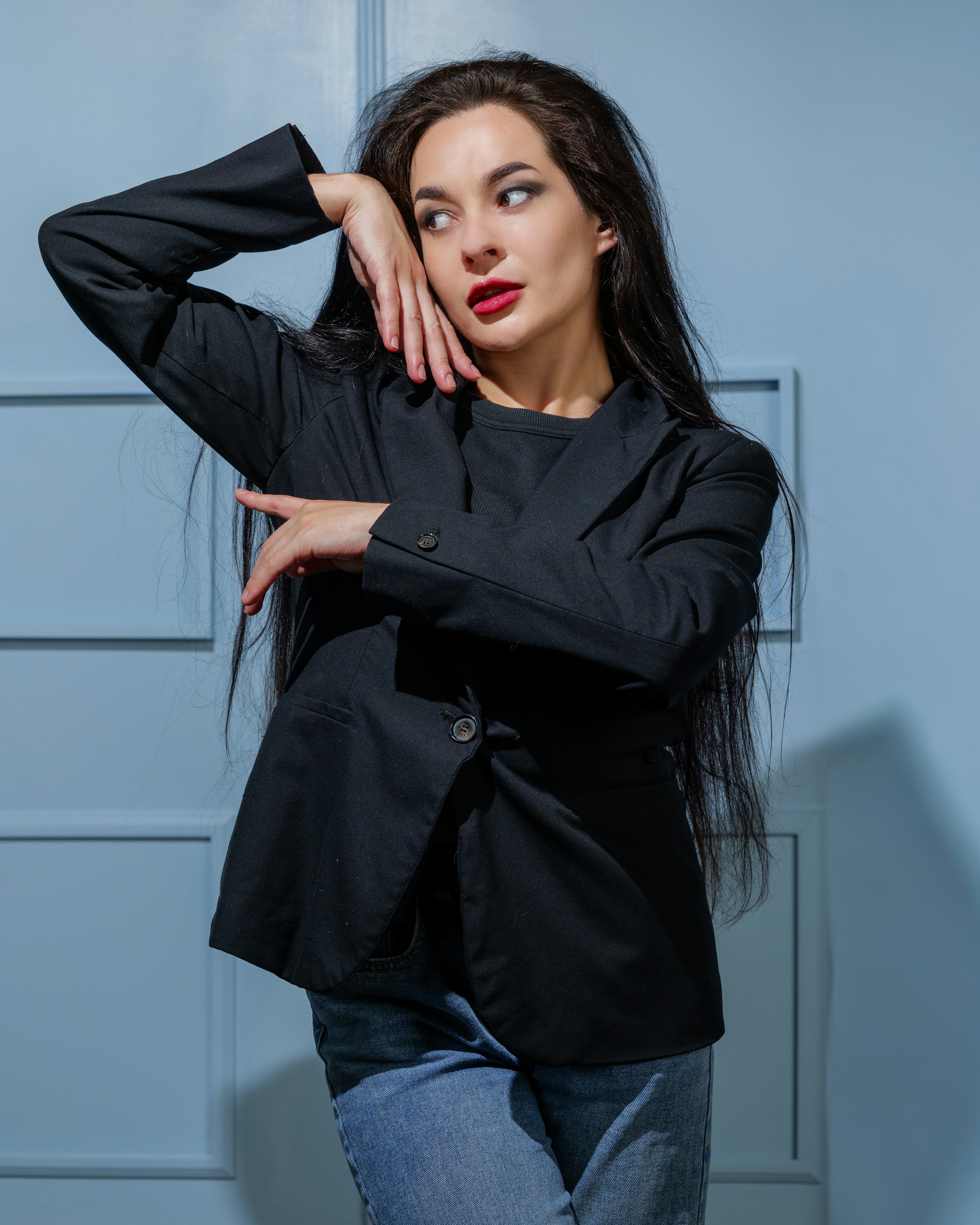 Elegance in Motion: A portrait of confident posture against a blue panel backdrop