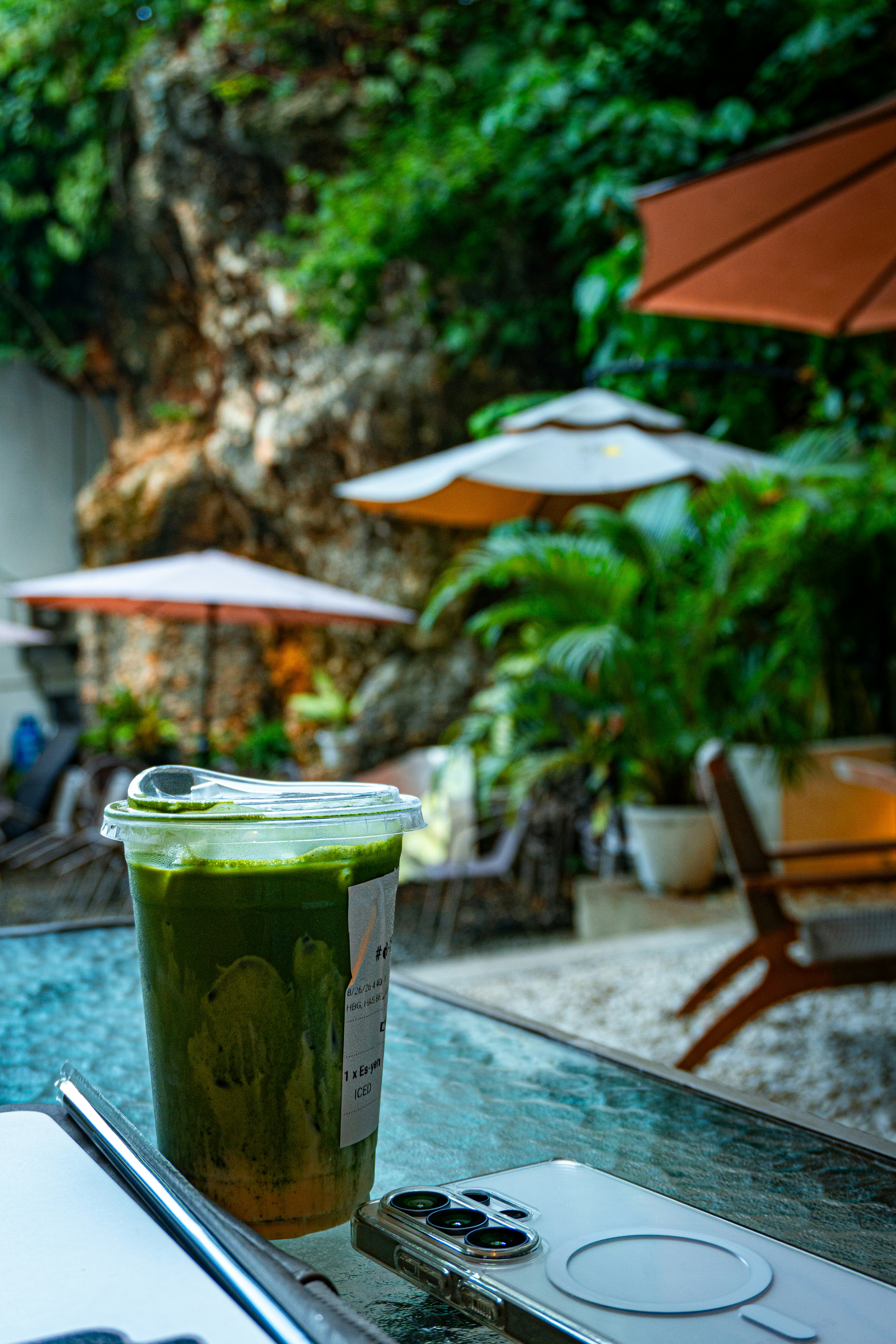 Green Drink, Quiet Oasis: A Café Scene with a Leaning Oasis of Umbrellas