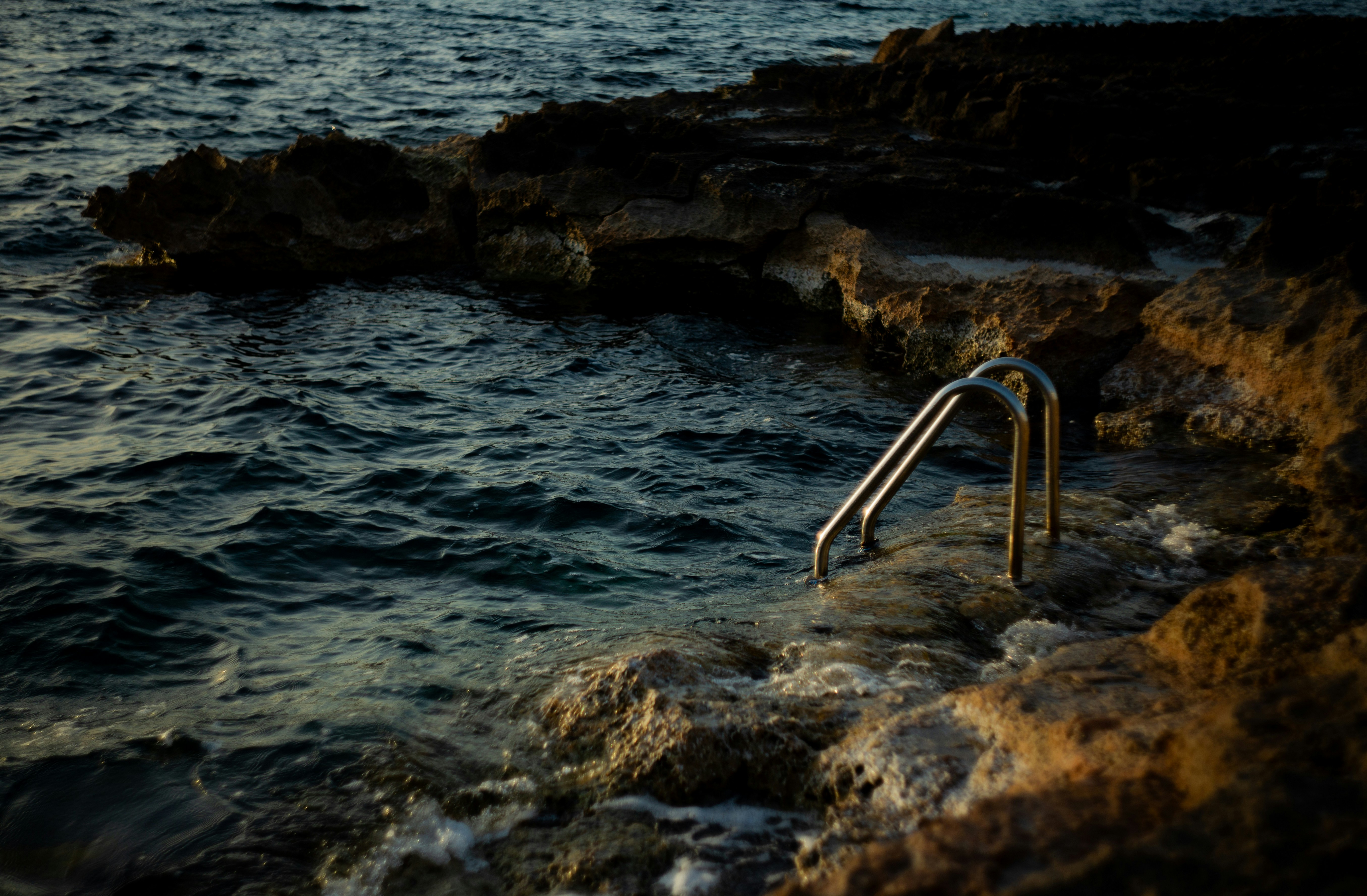 Ladder to the Sea: Quiet Tide on Weathered Rocks