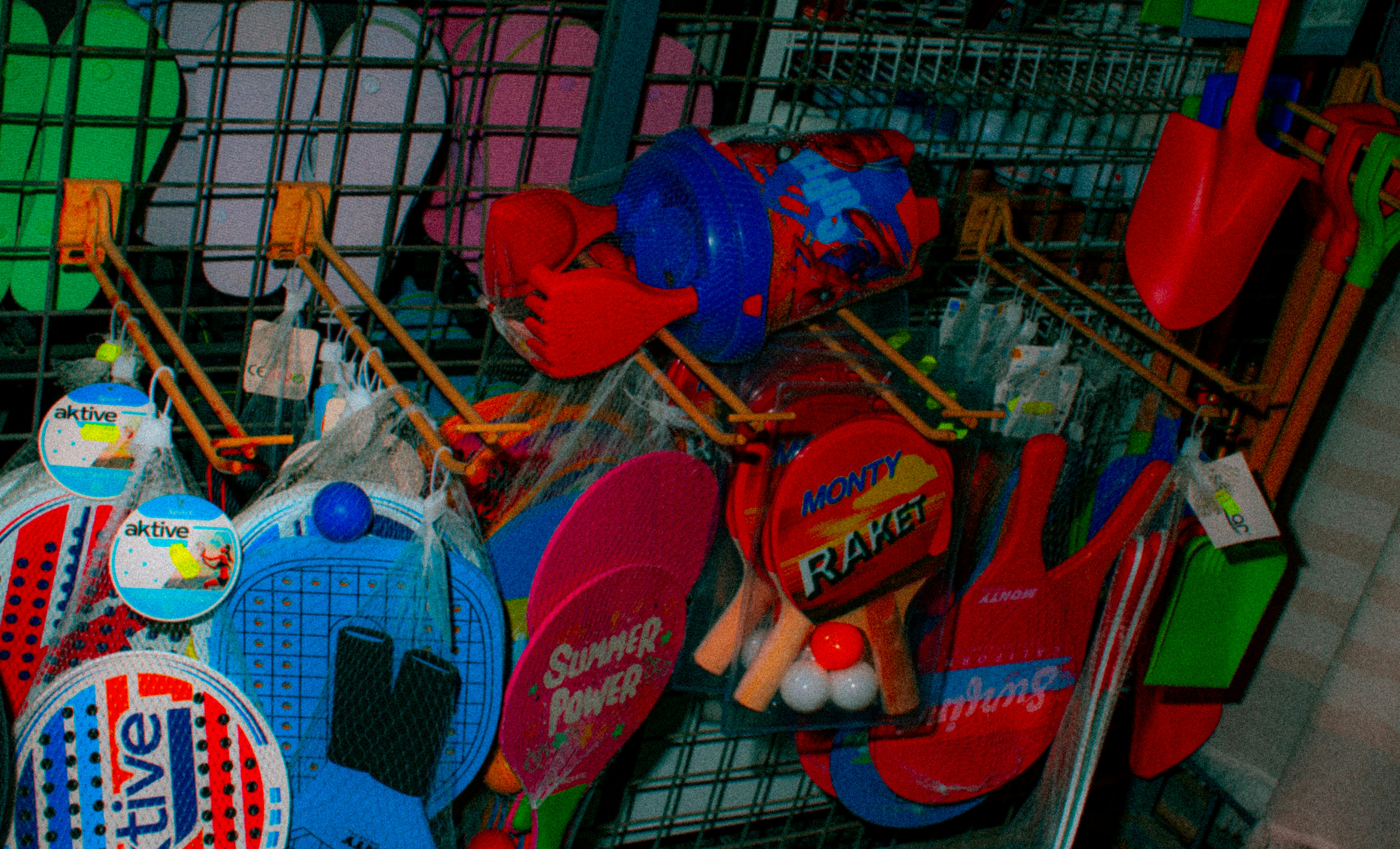 Colorful Toys in a Shuffled Storefront: A Collage of Beach Gear and Buckets
