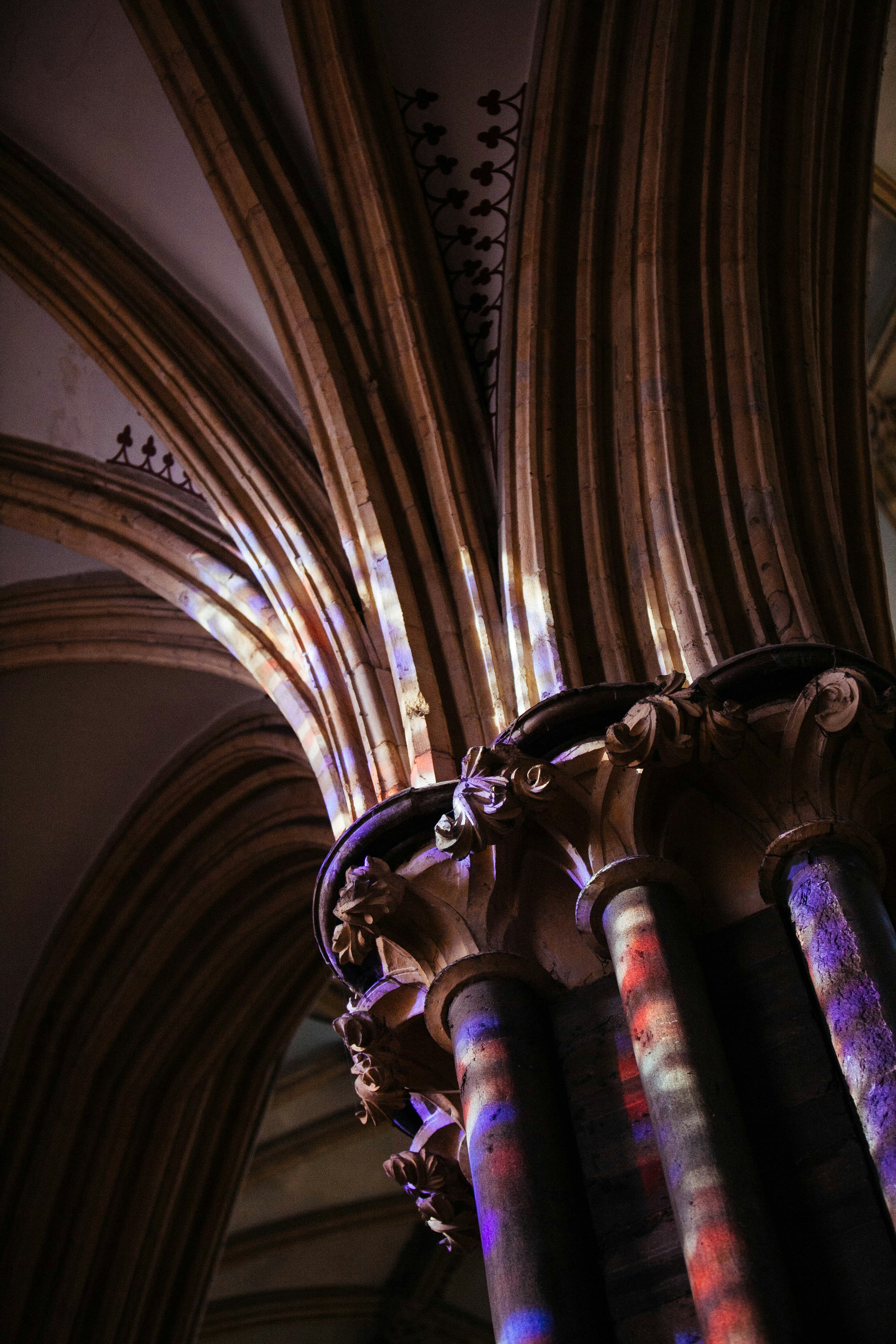 Stained glass light reflecting on a carved stone column in a cathedral