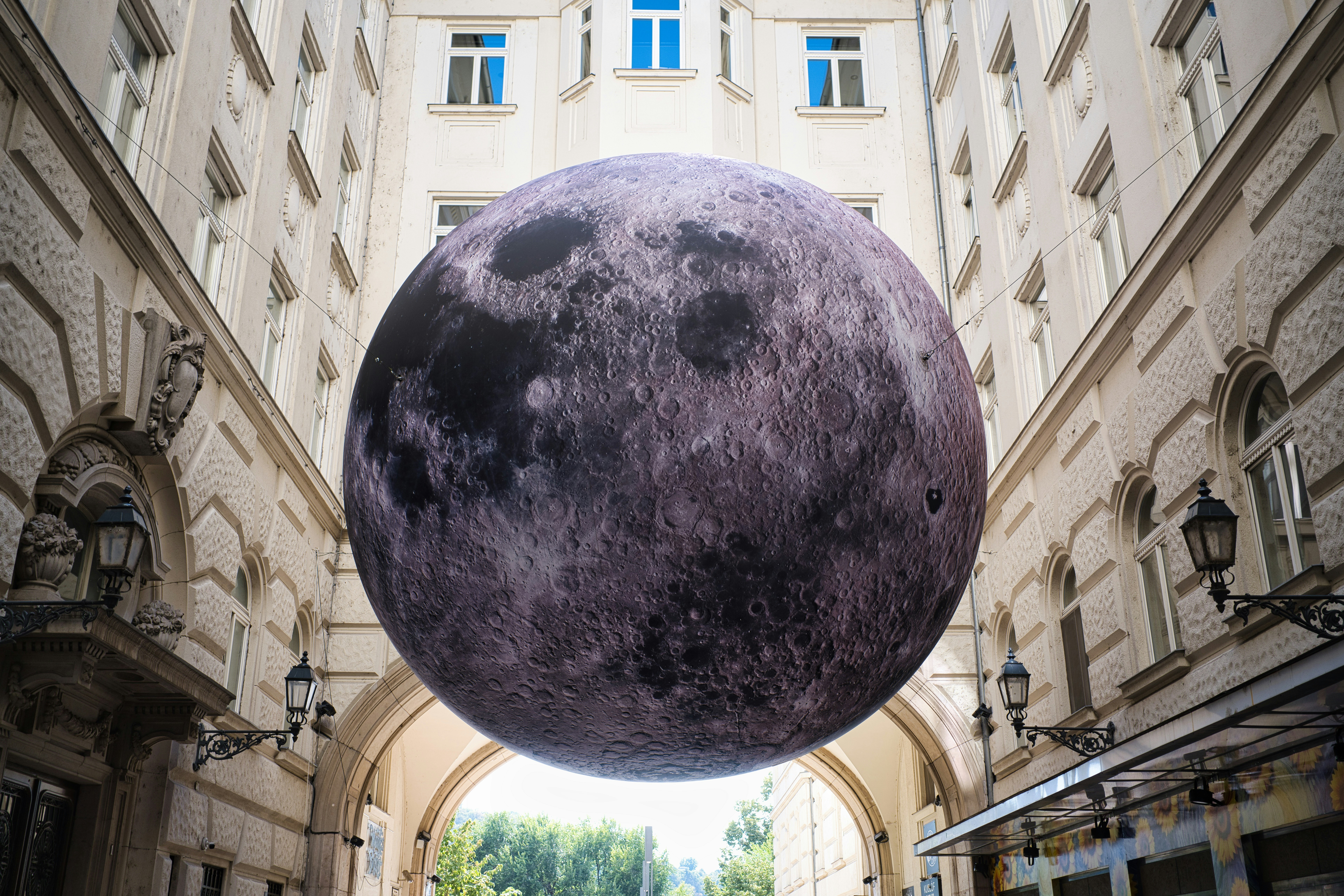 Moon Over a Courtyard: Giant Celestial Float Between Archways