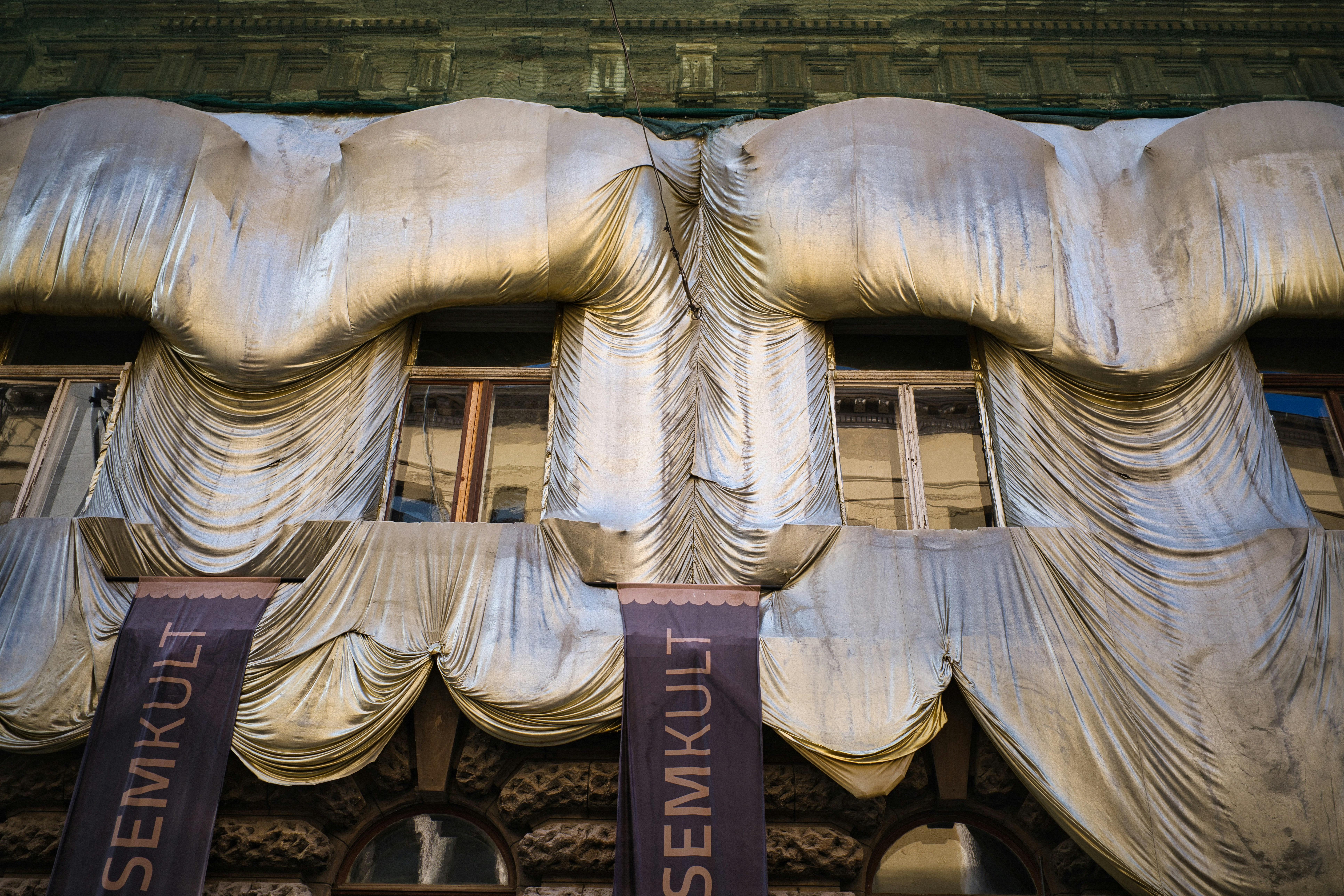 Draped Facade: Velvet Waves over a Historic Facade