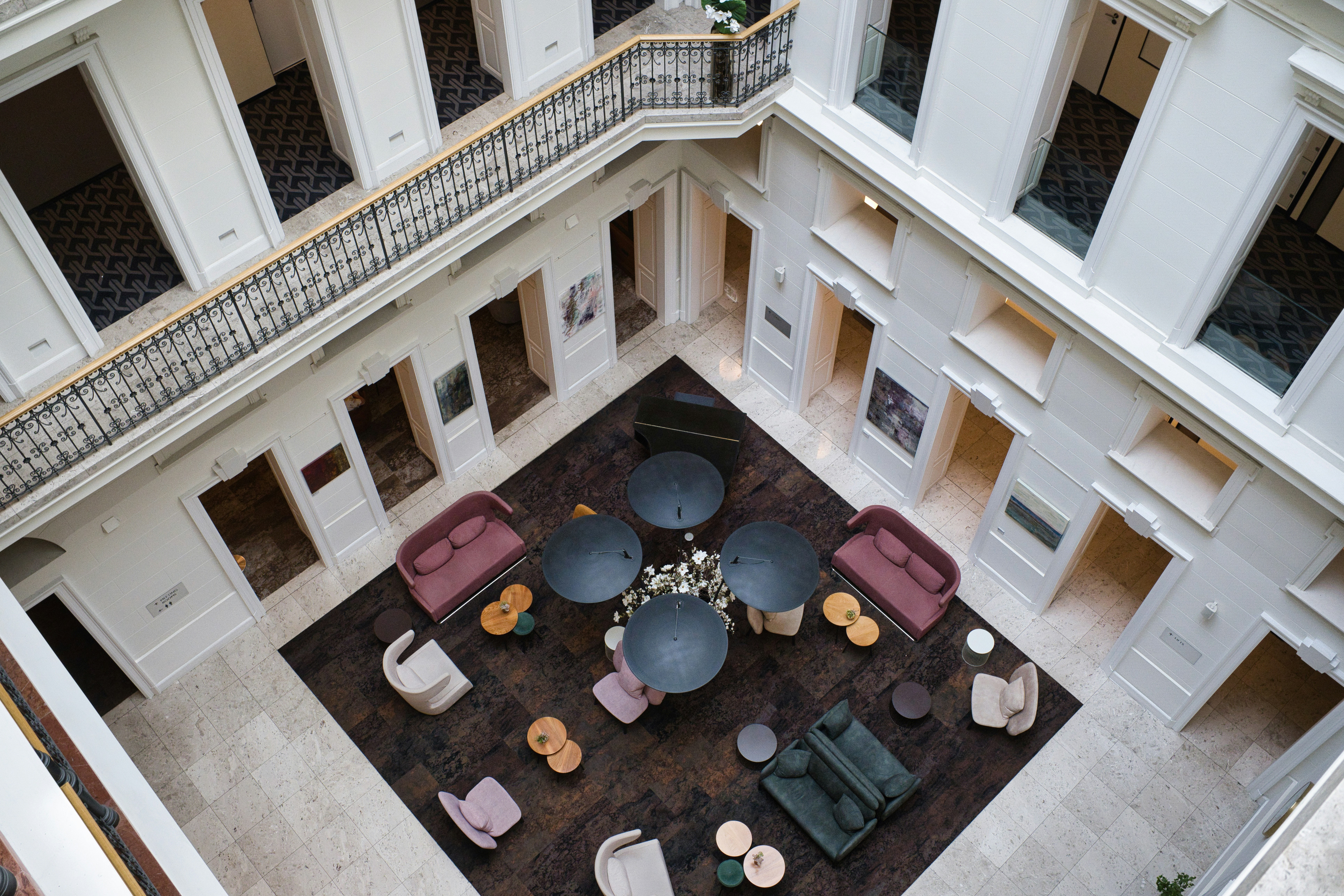 Aerial Lounge in the Atrium: Symmetry, Soft Seating, and Round Tables