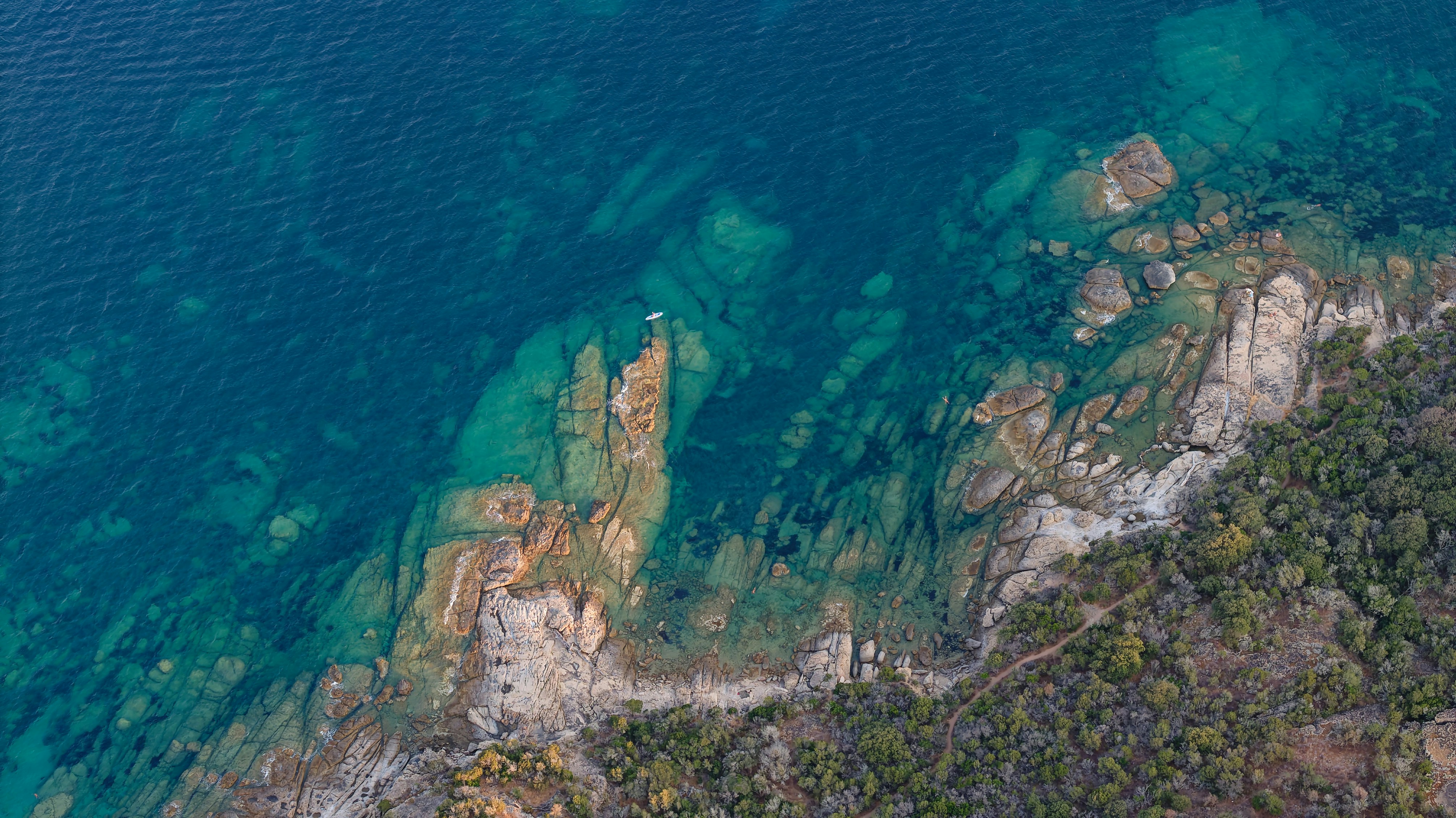 Aegean Interface: Sunlit Boulders Meet Turquoise Shallows