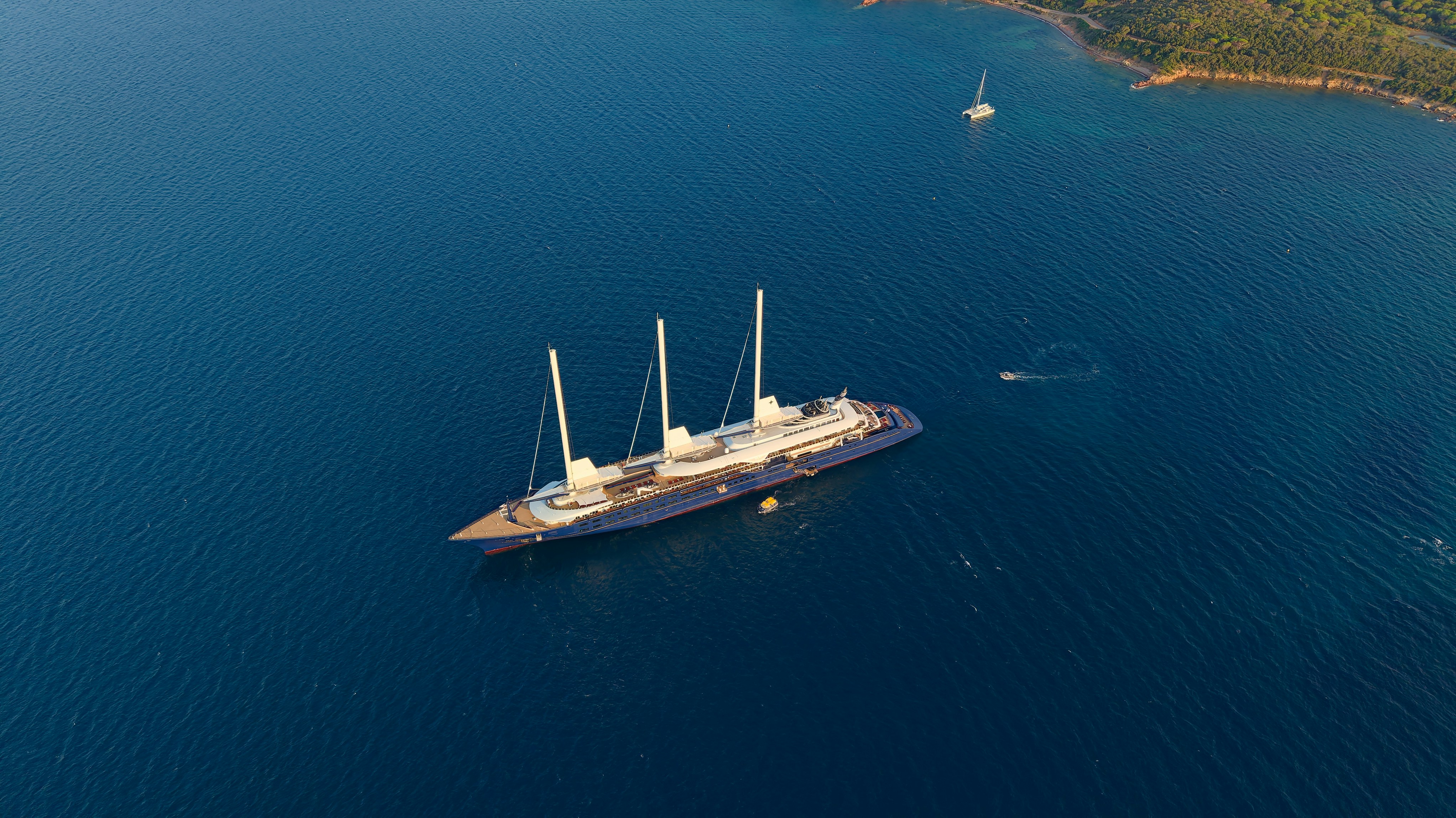 Sailing Monolith: A Three-Mail Sloop Anchored in Turquoise Silence