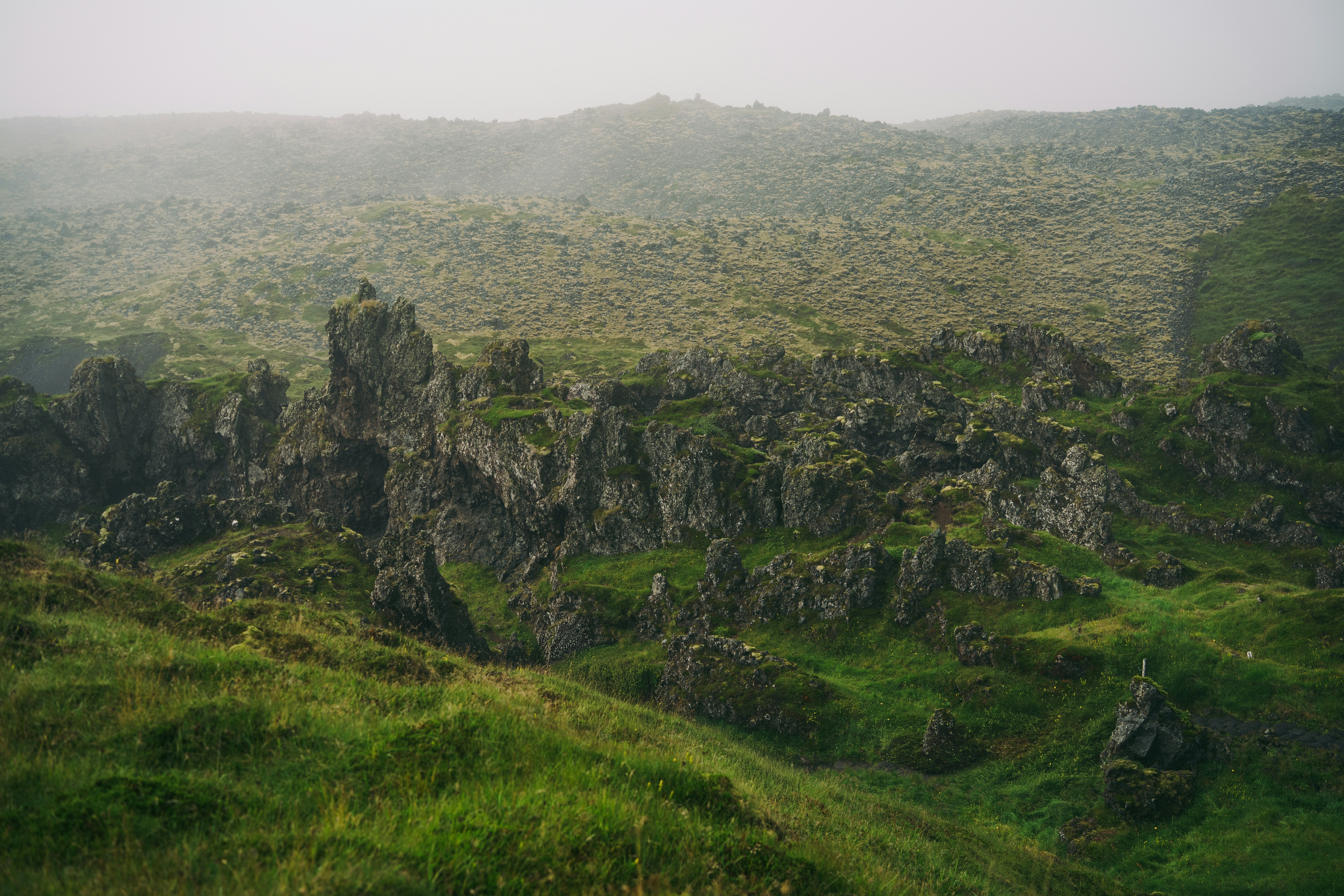 Rugged Limestone Outcrops Loom Over Verdant Hills