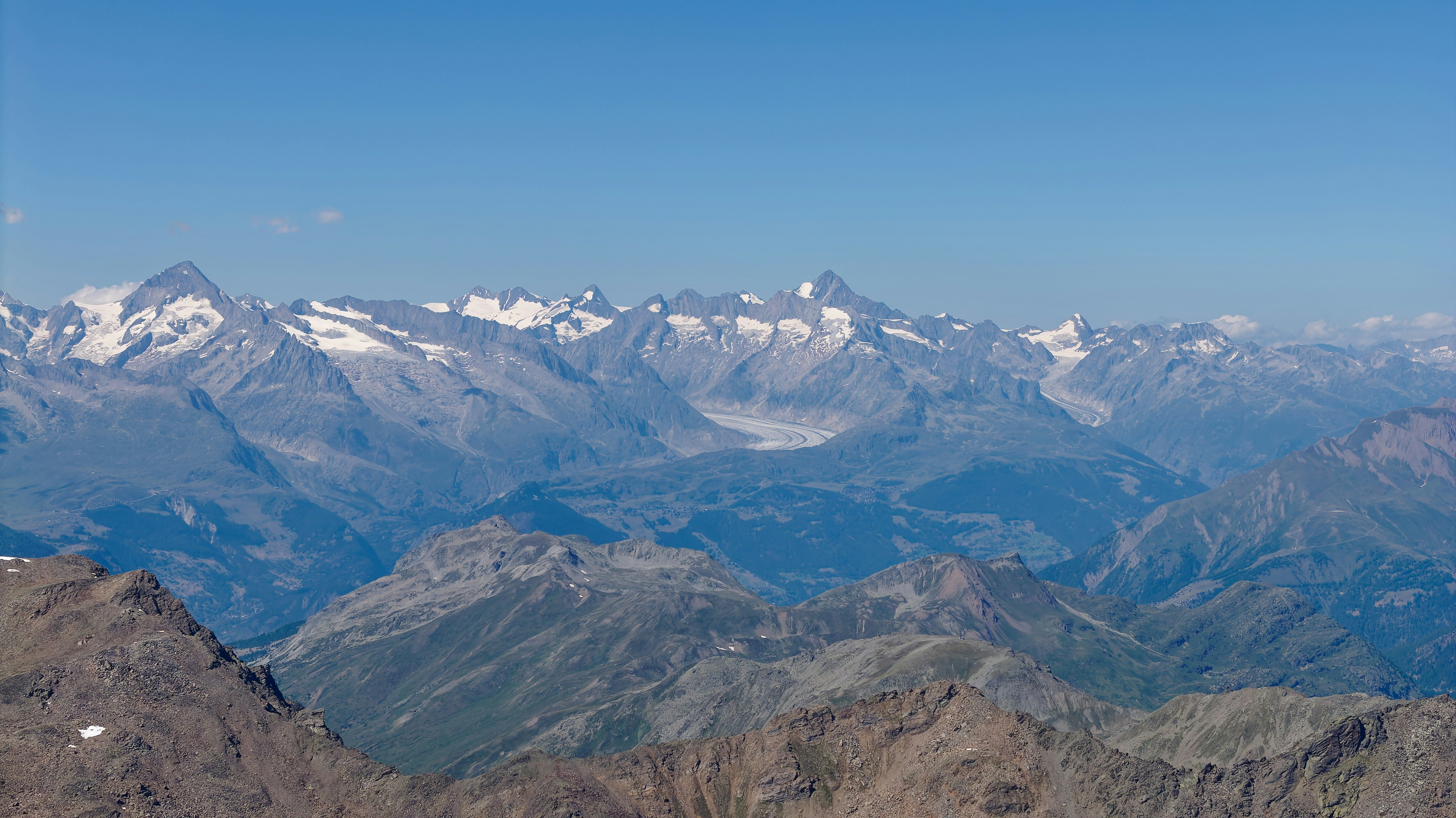 Aerial Summit: Snowbound Peaks beneath a Clear Alpine Sky
