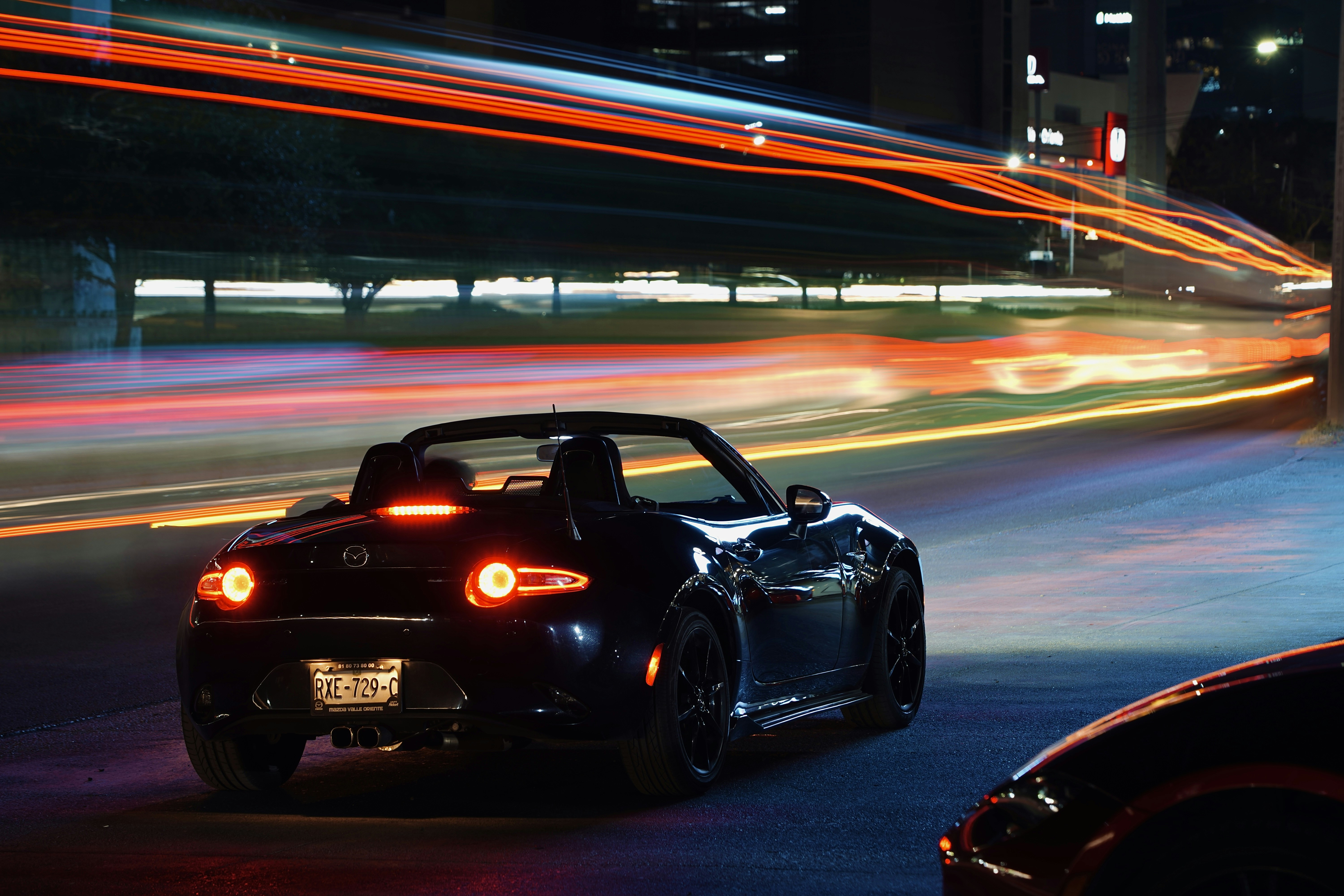 Midnight Convertible: Neon Trails and Red-Tailed Lights