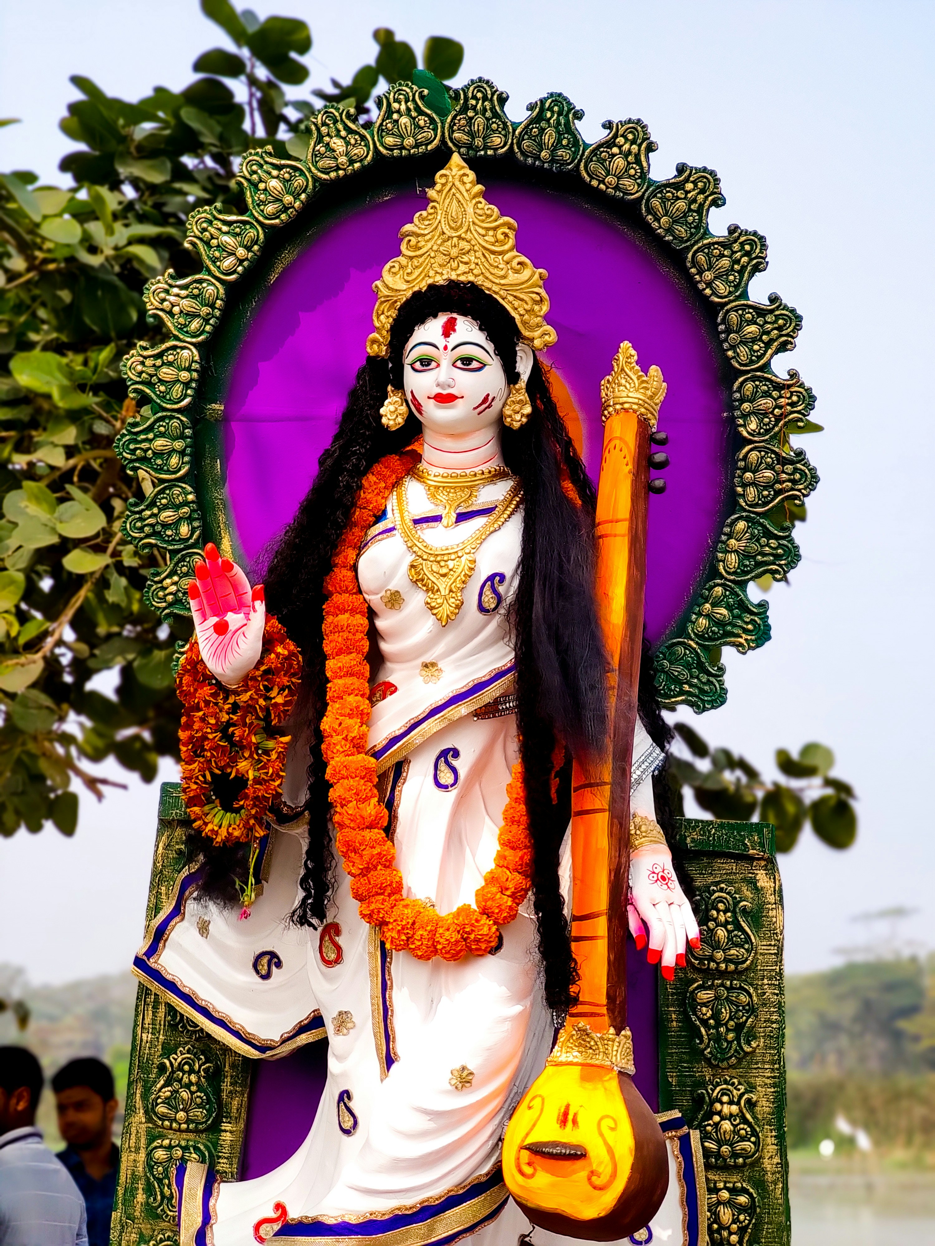 Divine Statue Amid Ornate Backdrop at a Colorful Festival