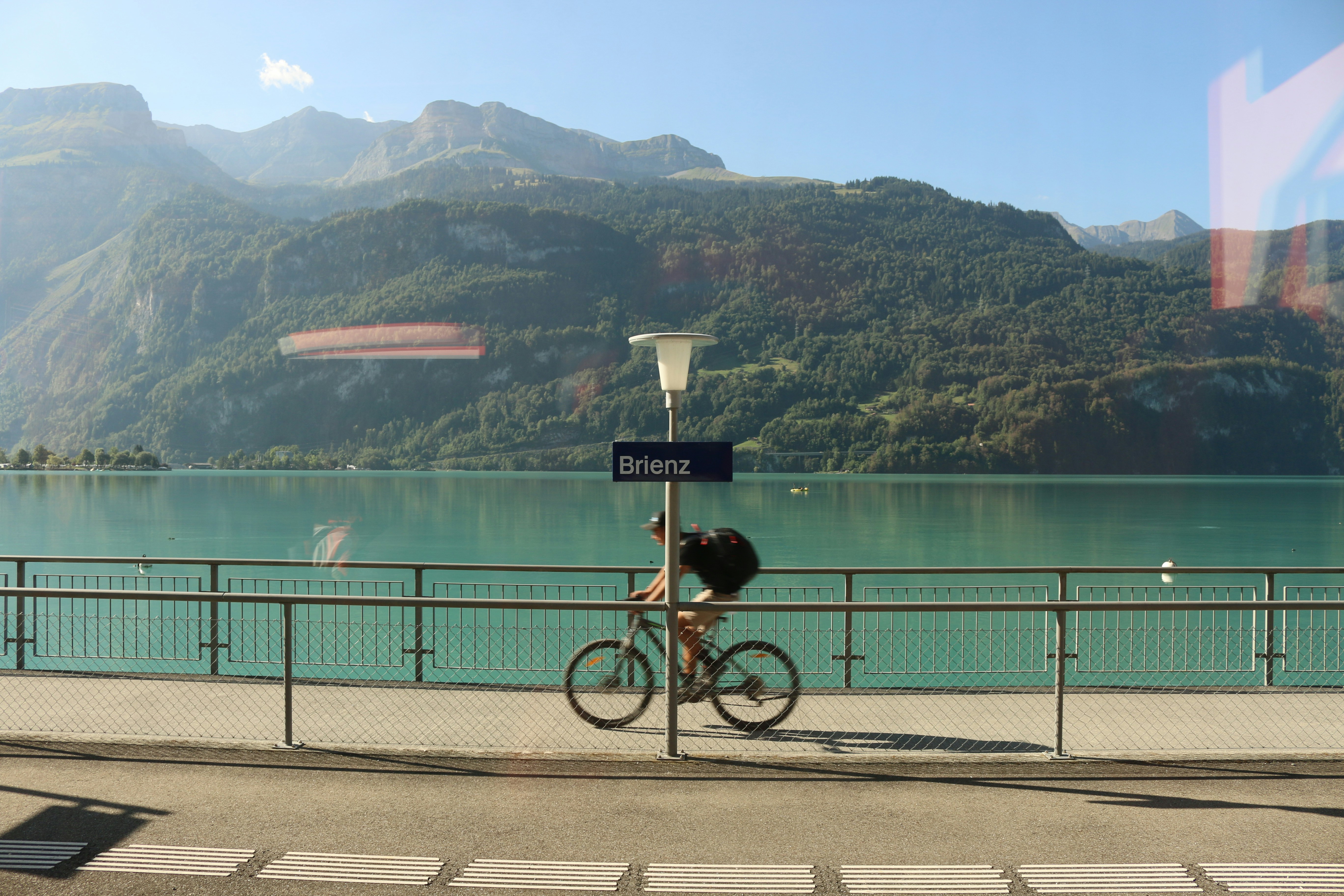 Cyclist Crossing Brienz Promenade Under Alpine Backdrop