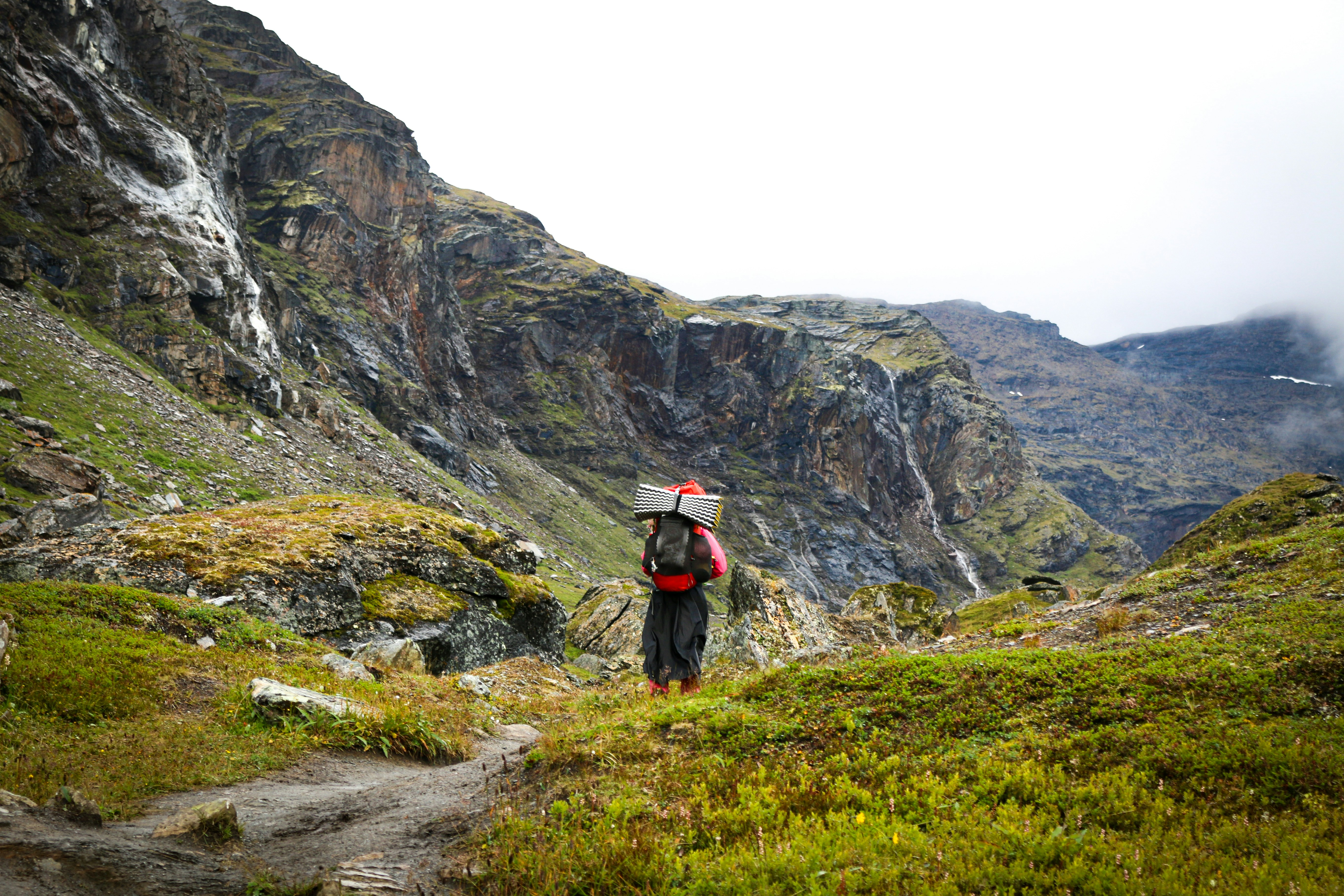 Highland Trek: A Lone Carrier Among towering Ridges