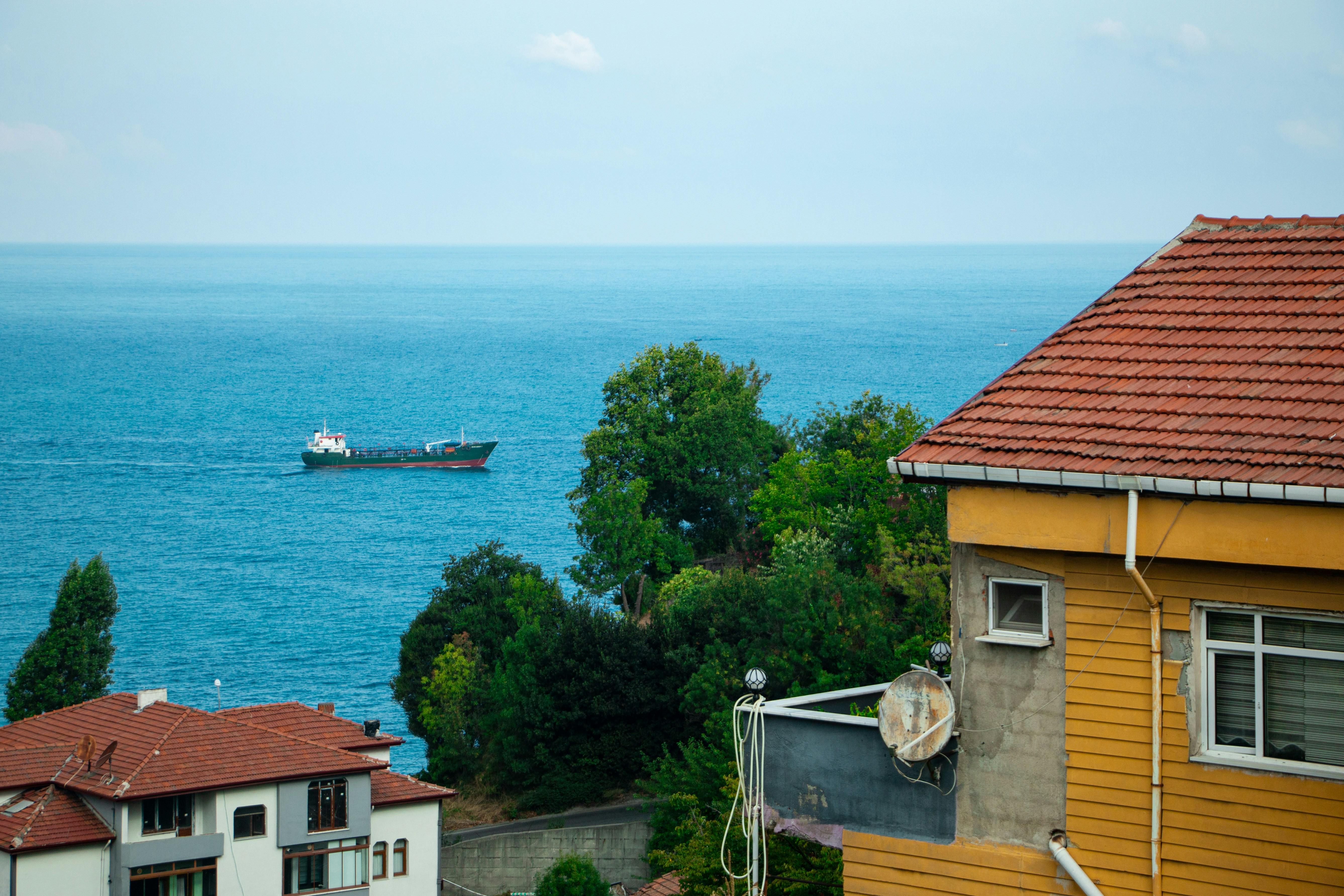 Coastal Terrace: A Yellow-Walled Building Greeted by Sea Breeze and Distant Wake