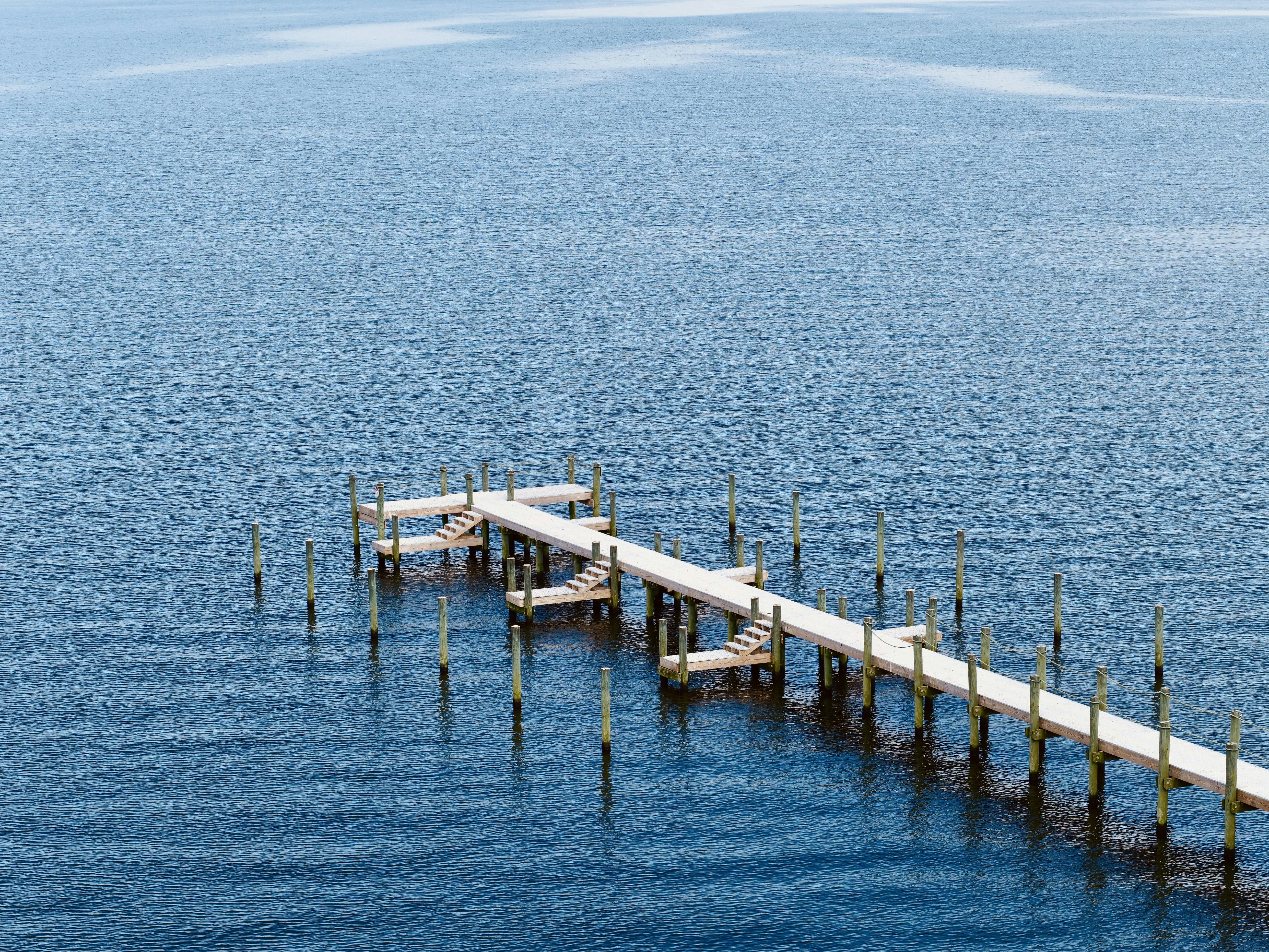 Pier extending into calm blue waters under a clear sky