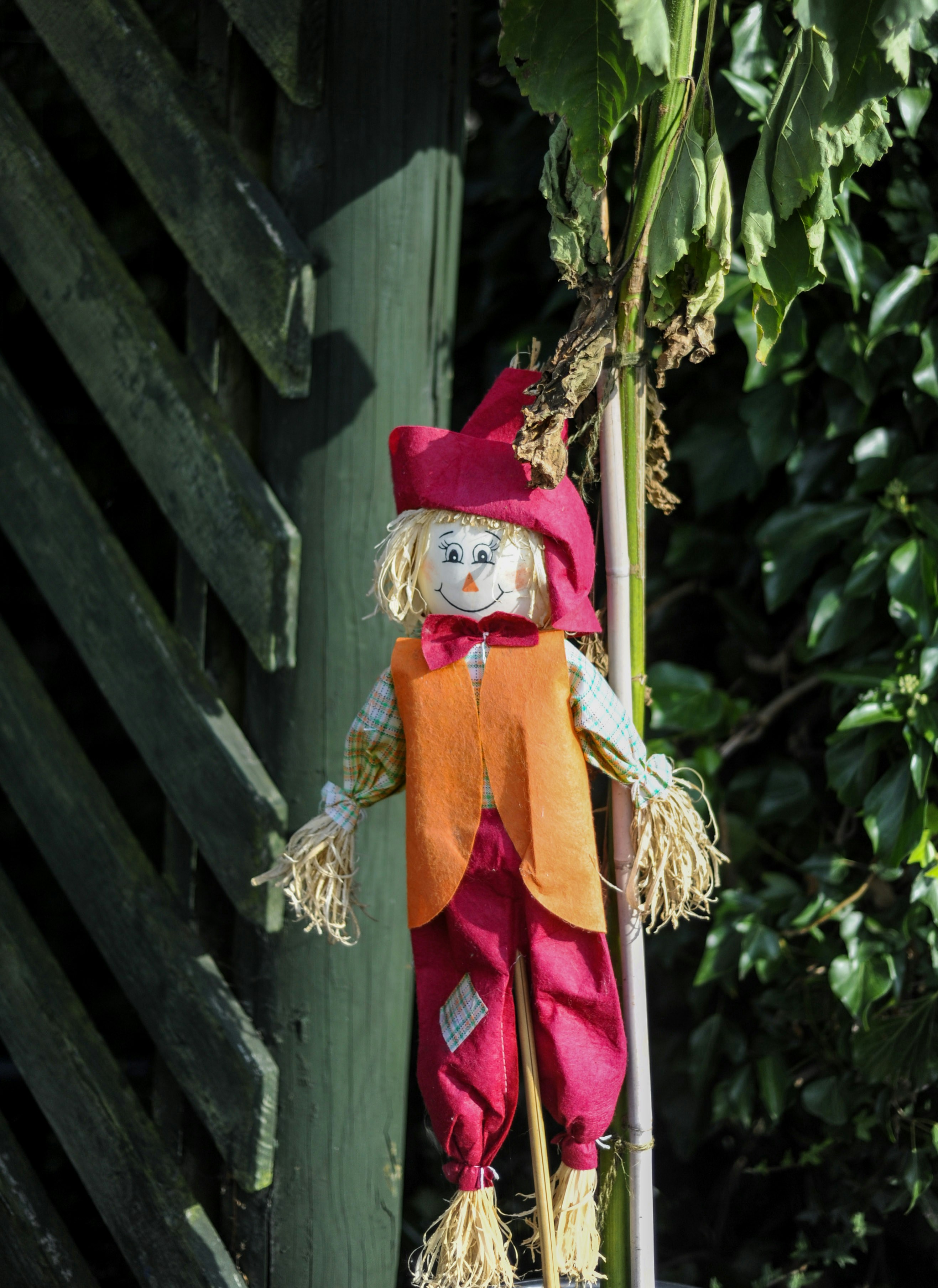 Whimsical Marionette Leaning Against a Garden Fence