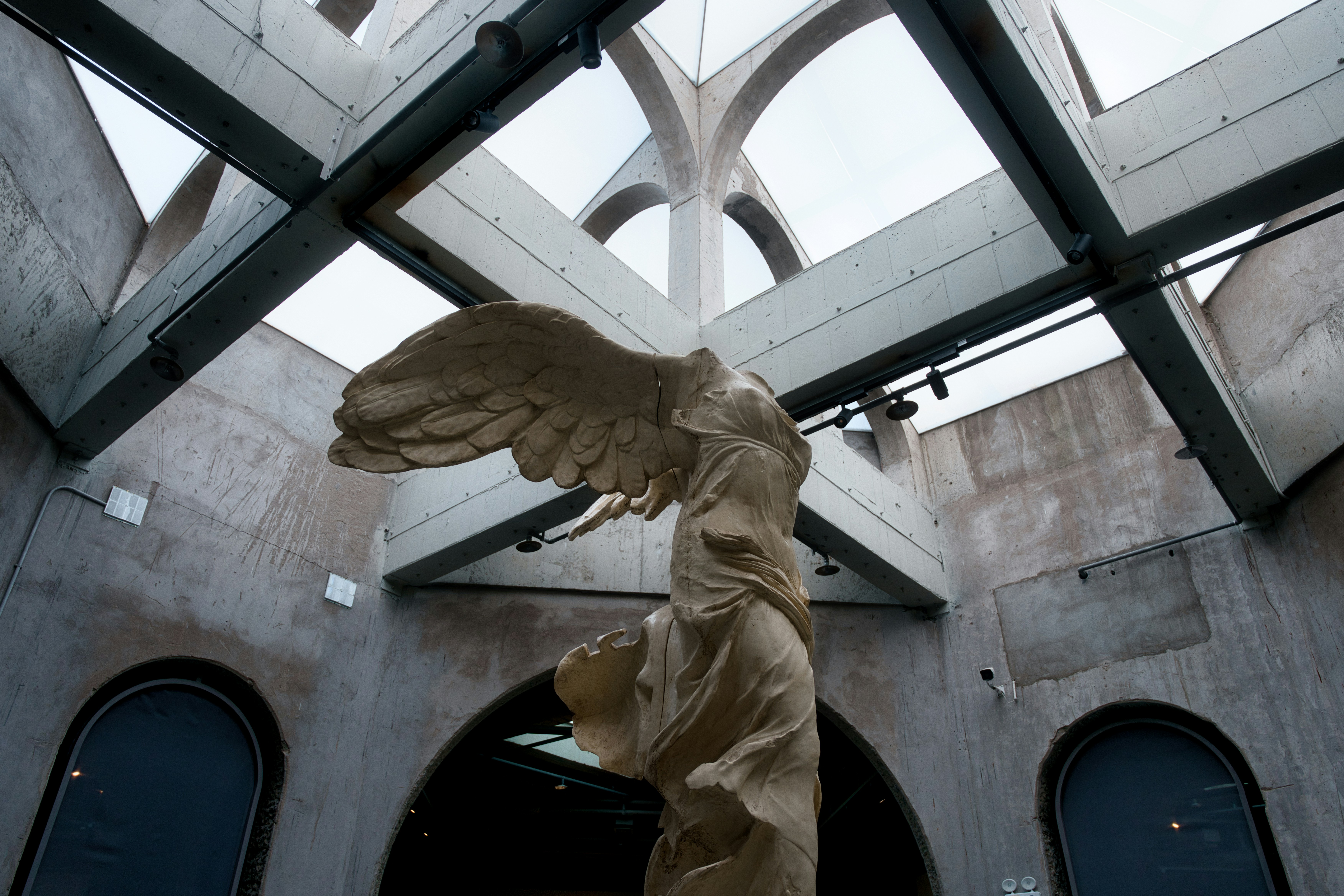 Winged Guardian in an Atrium of Concrete Arches