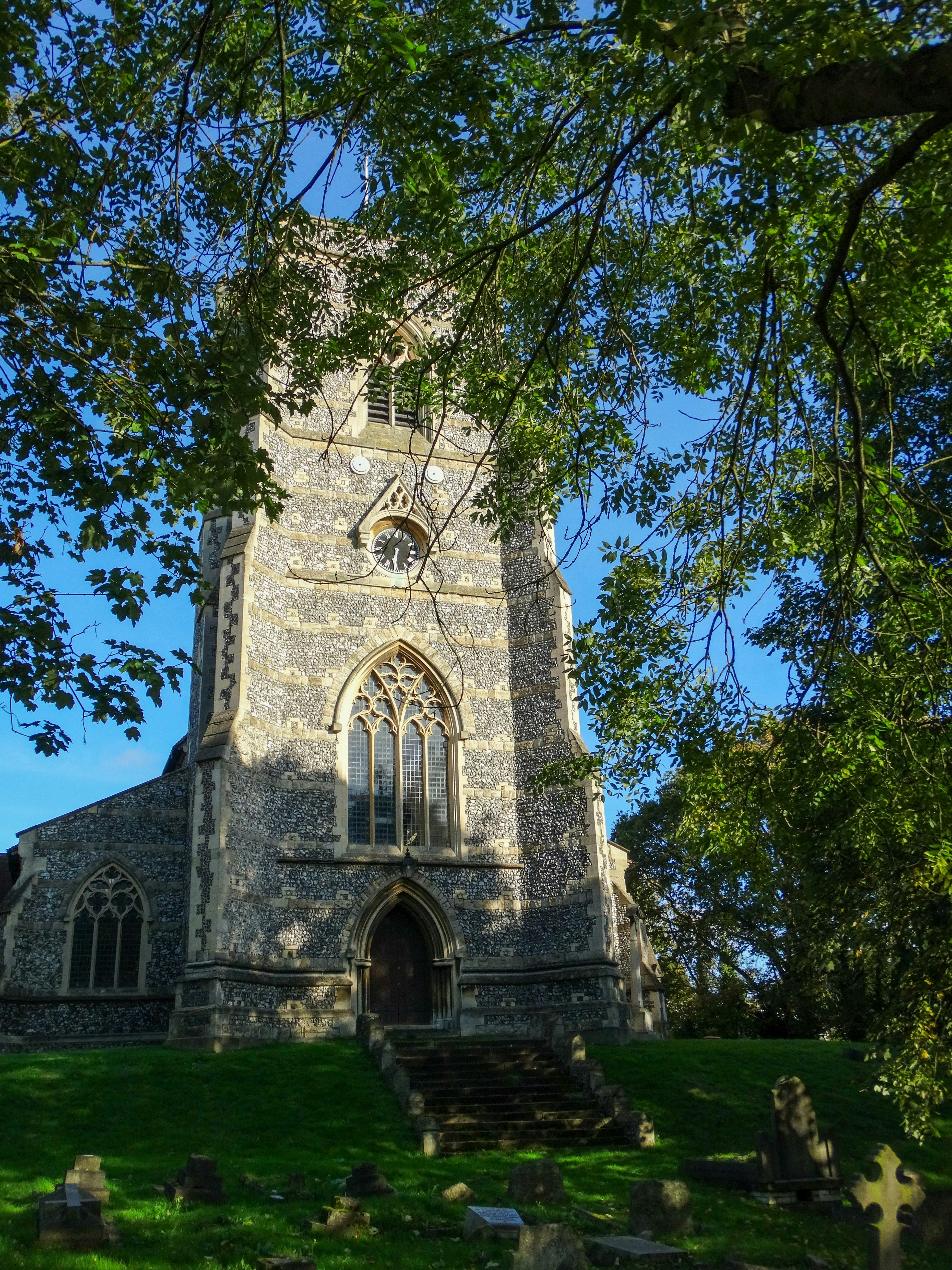 Stone Bell Tower in Sunlit Churchyard