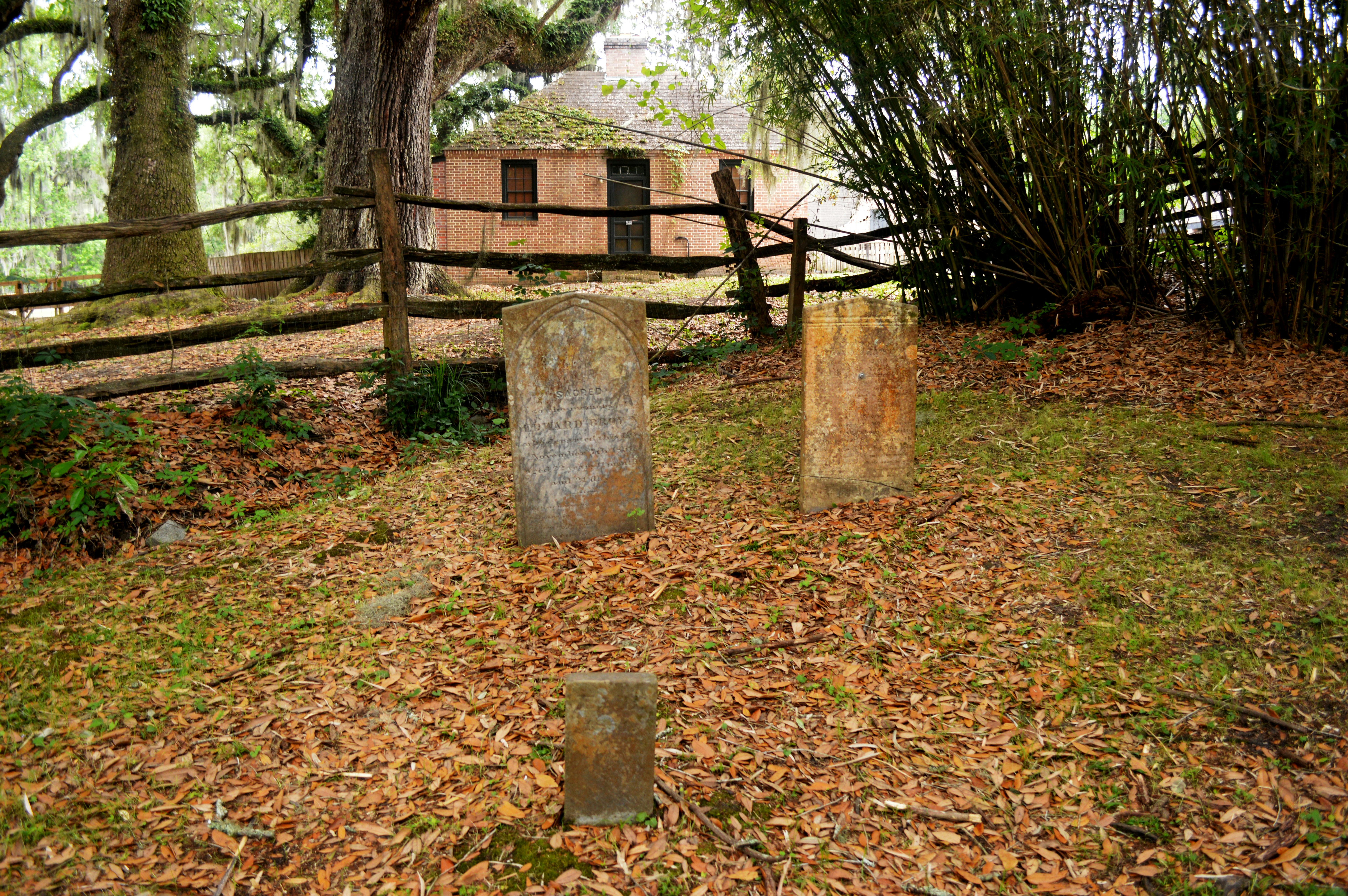 Three Weathered Gravemarkers in a Leaf-Littered Yard