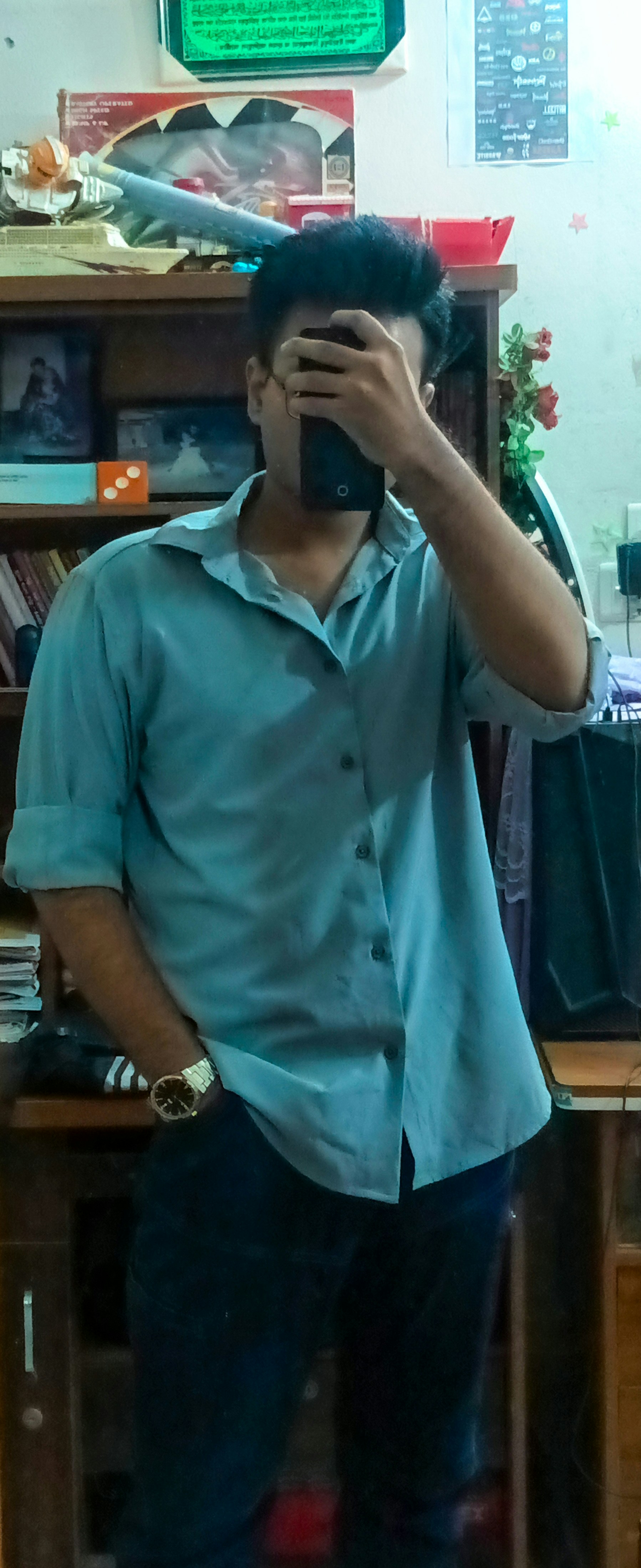 Self-portrait in a cluttered study: teal shirt and mirrored gaze