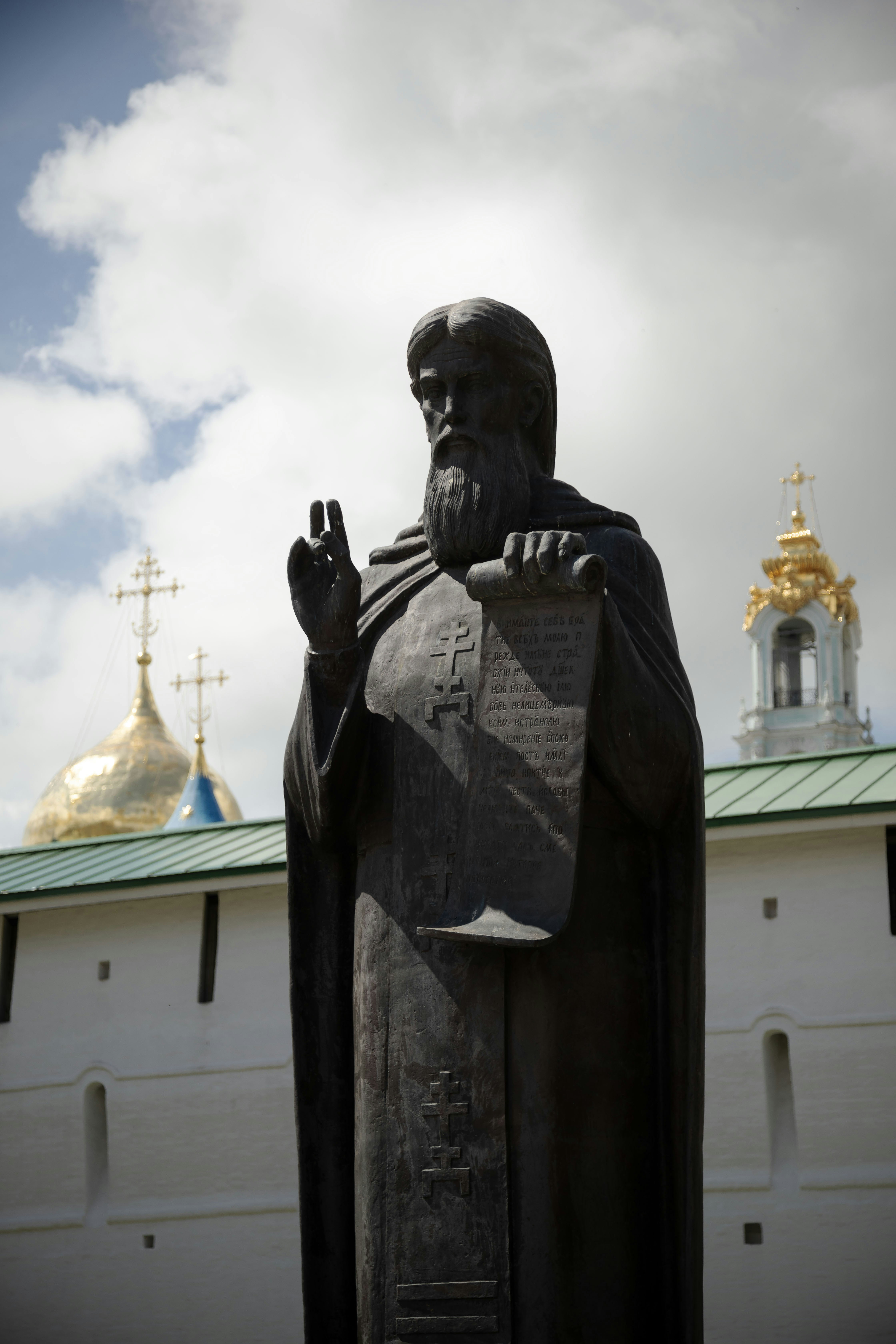 Stone Saint with Raised Hand and Scroll, Quietly Guarding a Sacred Courtyard