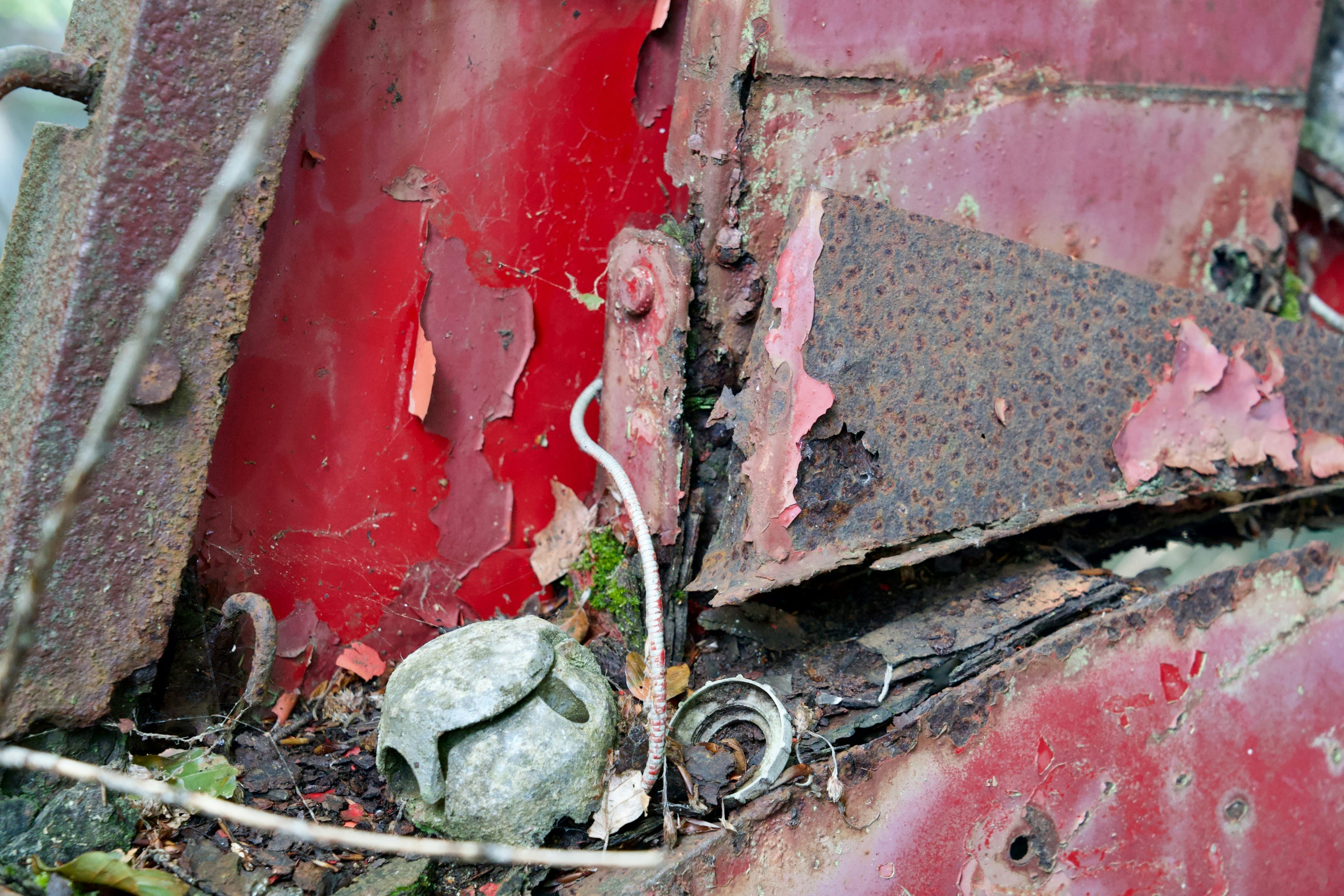 Rusted Red Barrier with Frayed Cables and Moss