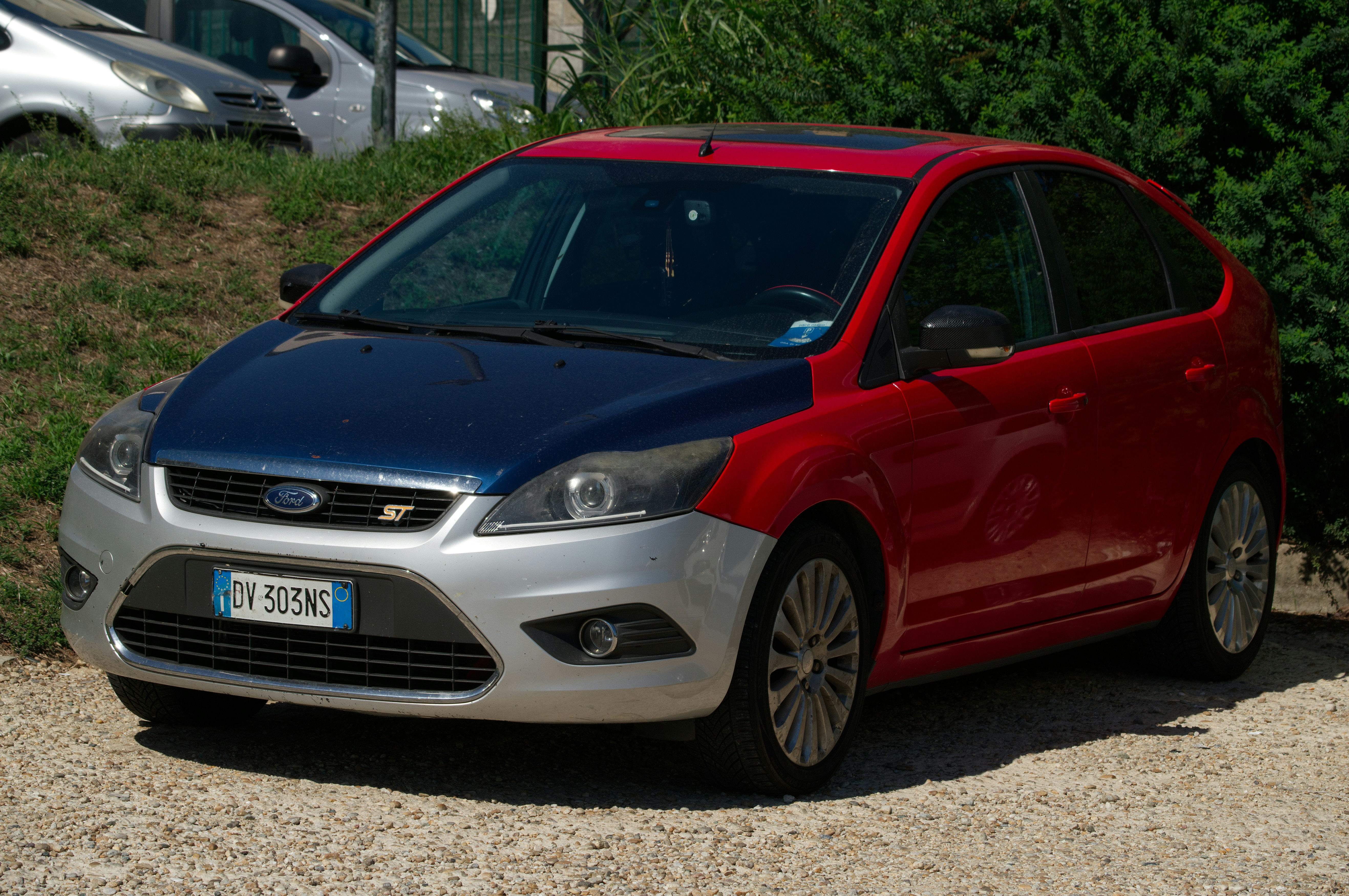 Colorfully styled Ford Focus sedan parked on a gravel lot with a two-tone paint job and a European license plate.