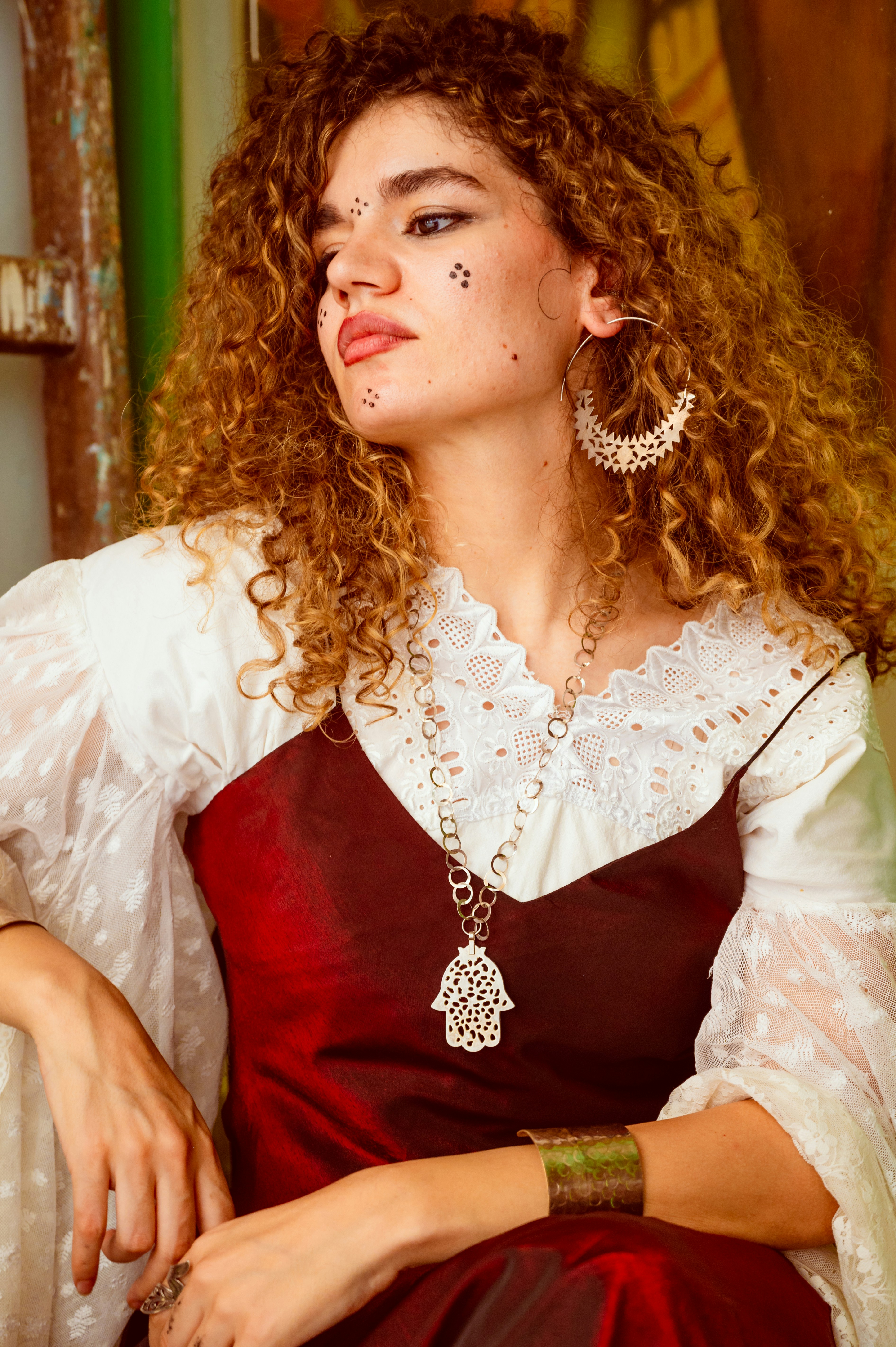 Curled moments: a regal gaze framed by vintage lace and bold motifs