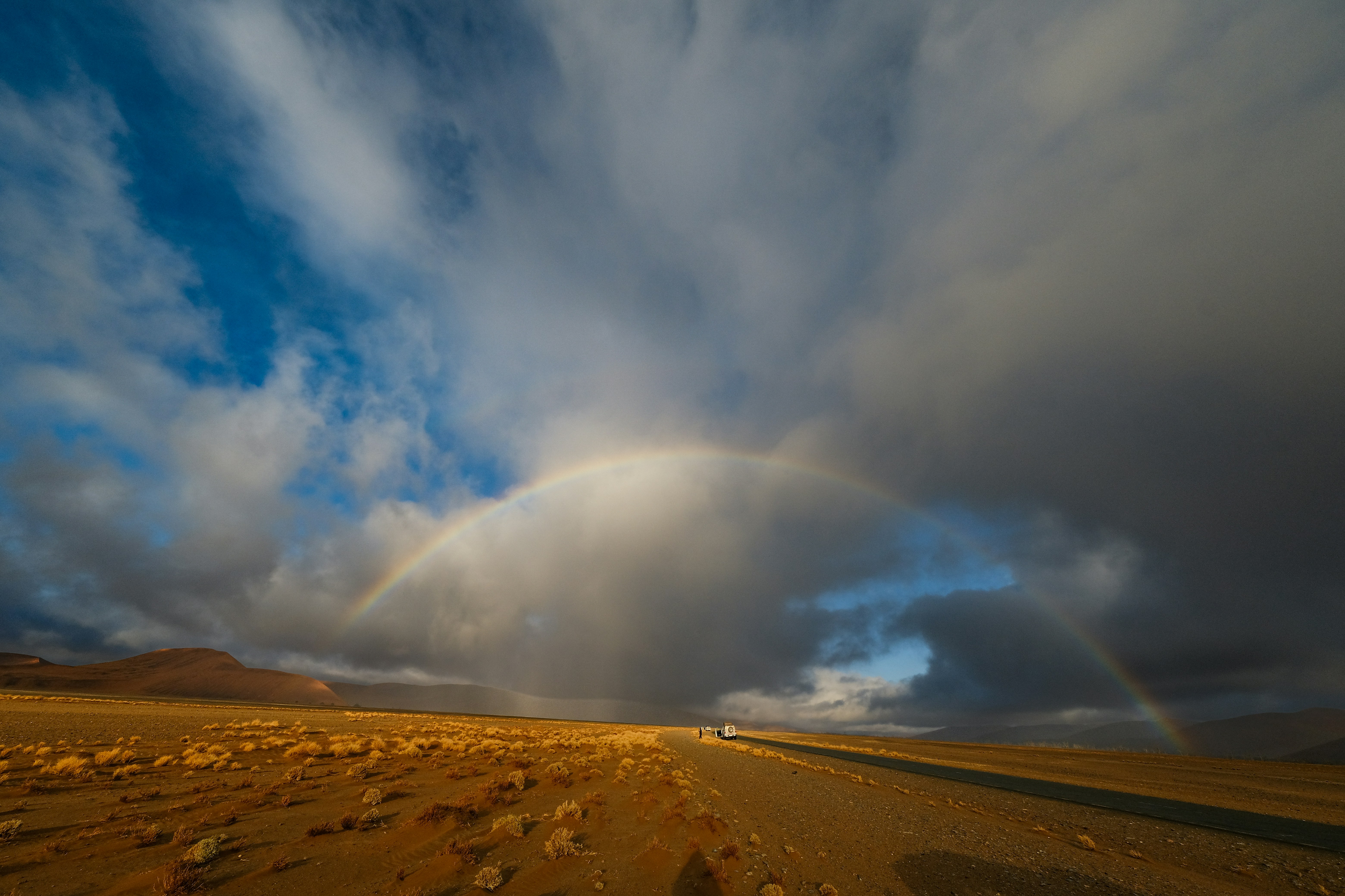 Double Arc of Light: A Desert Road Under a Full Rainbow