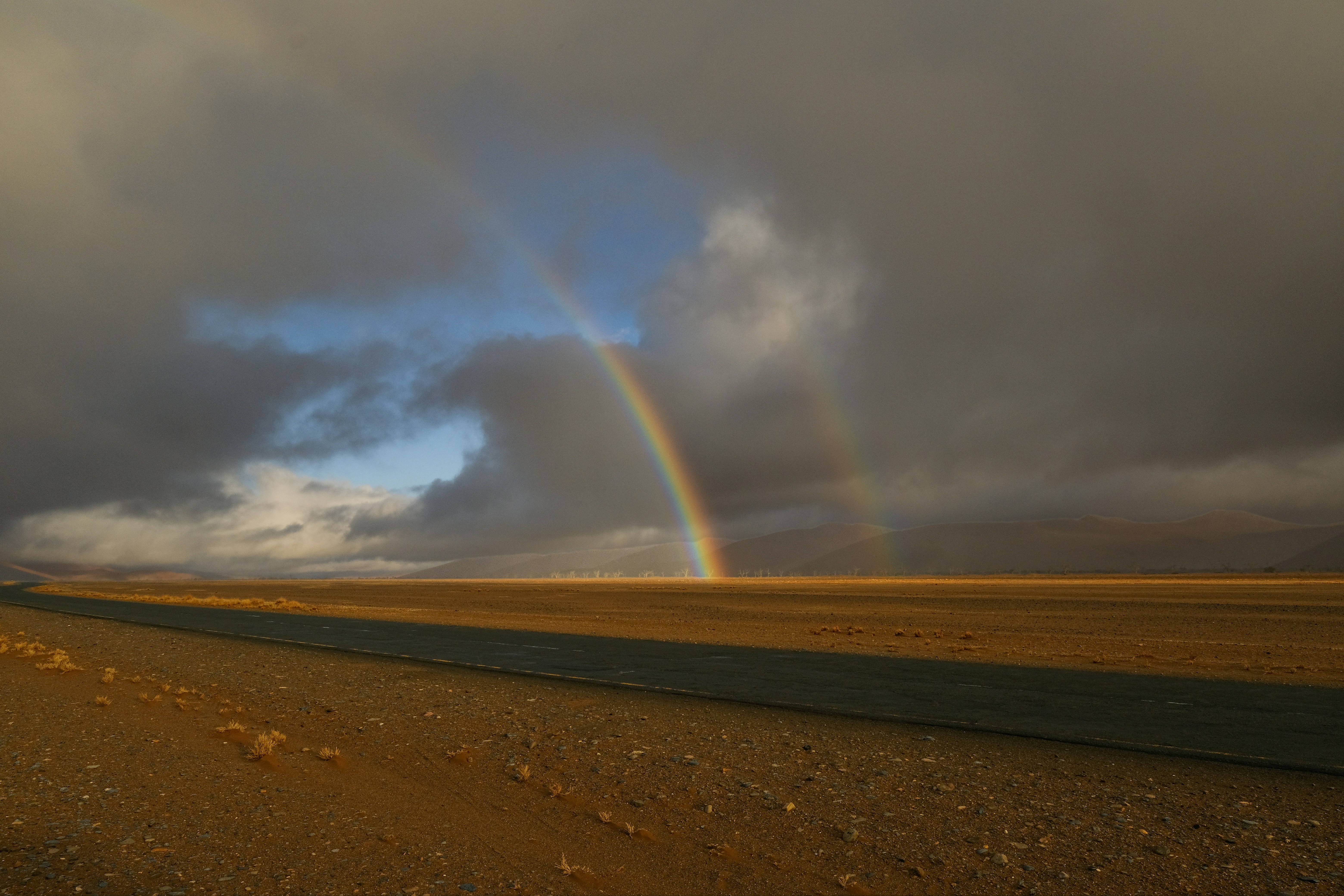 Double Rainbow Over a Desolate Road