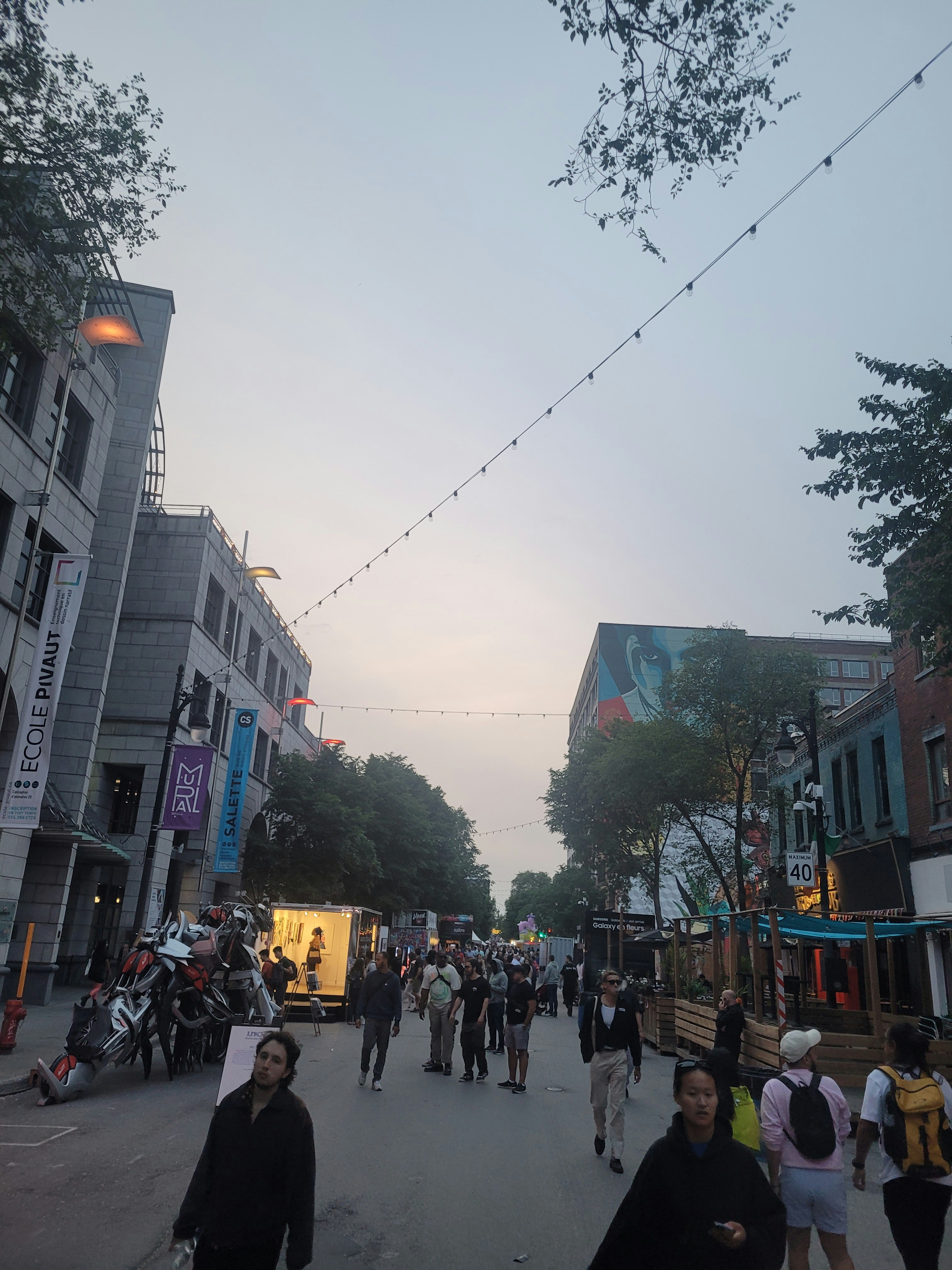 City Street Pulse: People, Lights, and Evening Sky