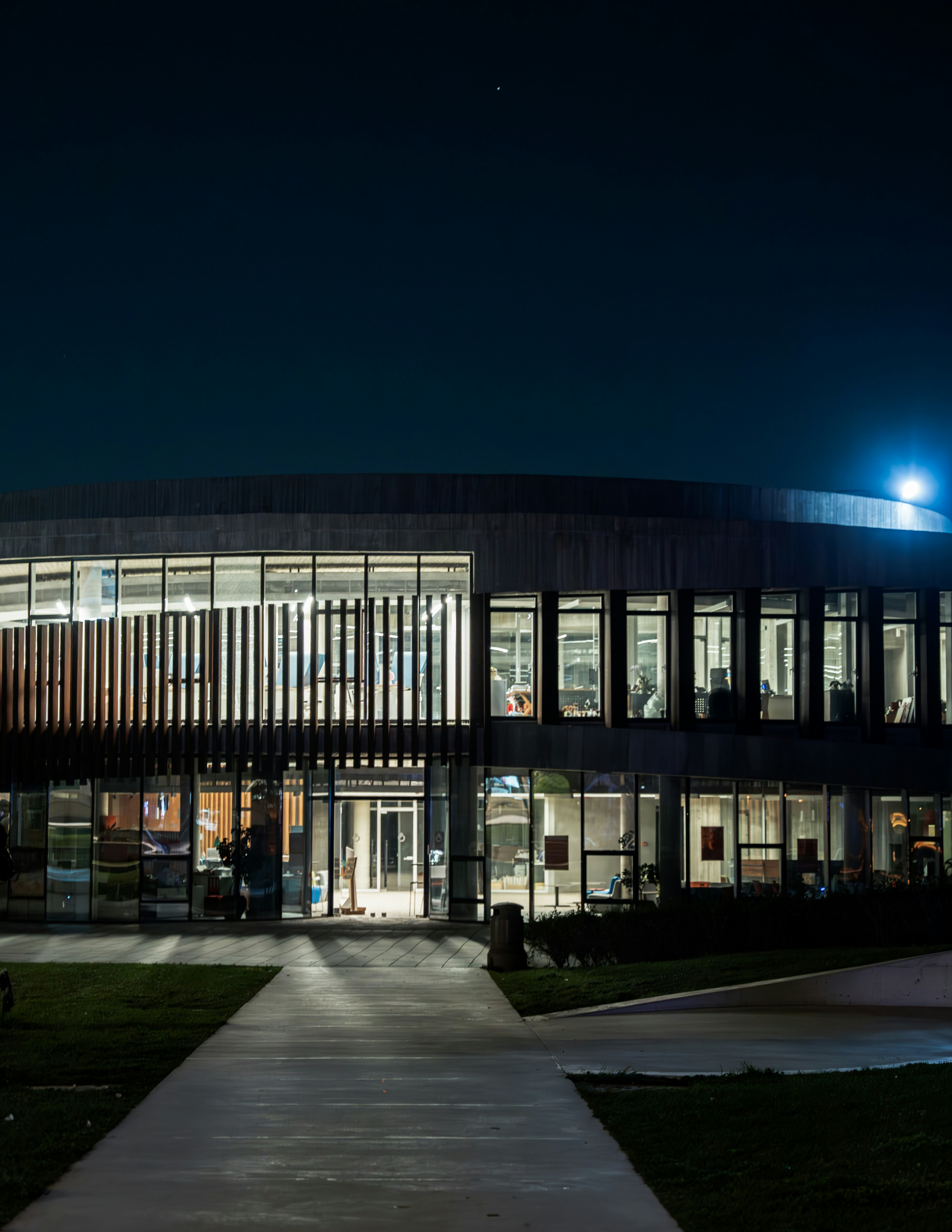 Nighttime at the Glass Facade: Office Lights Through Slatted Shade