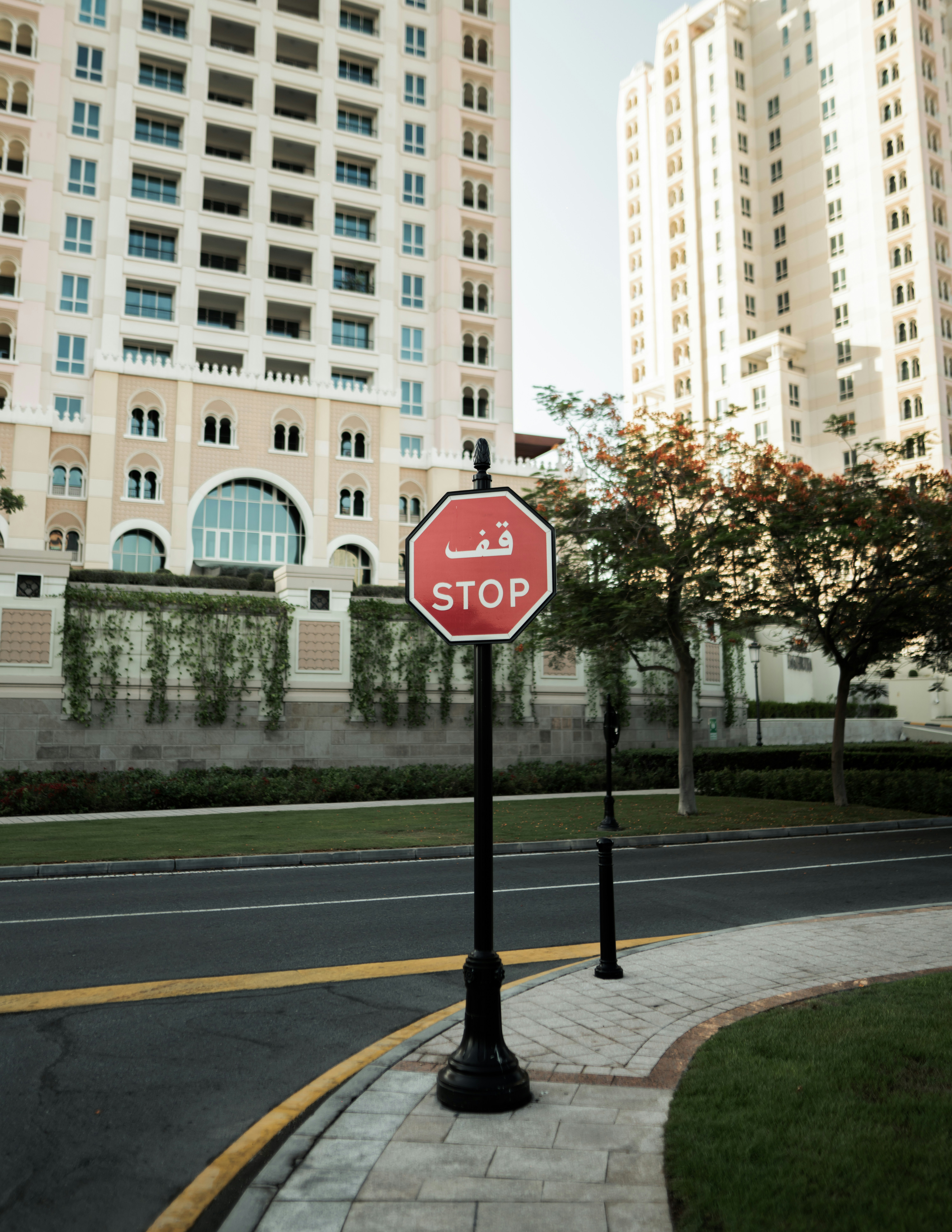 Urban Stop Sign: Arabic Script and Towering Residential Facades