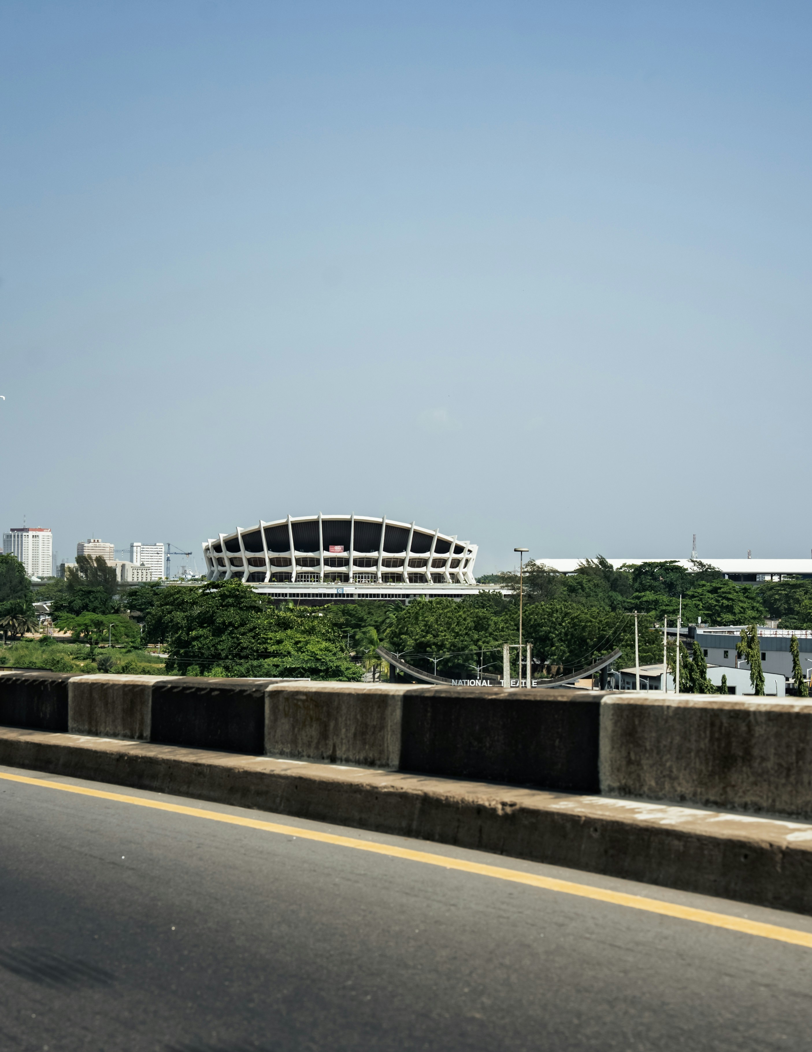 Stadium Silhouette Rising Beyond a Quiet Road