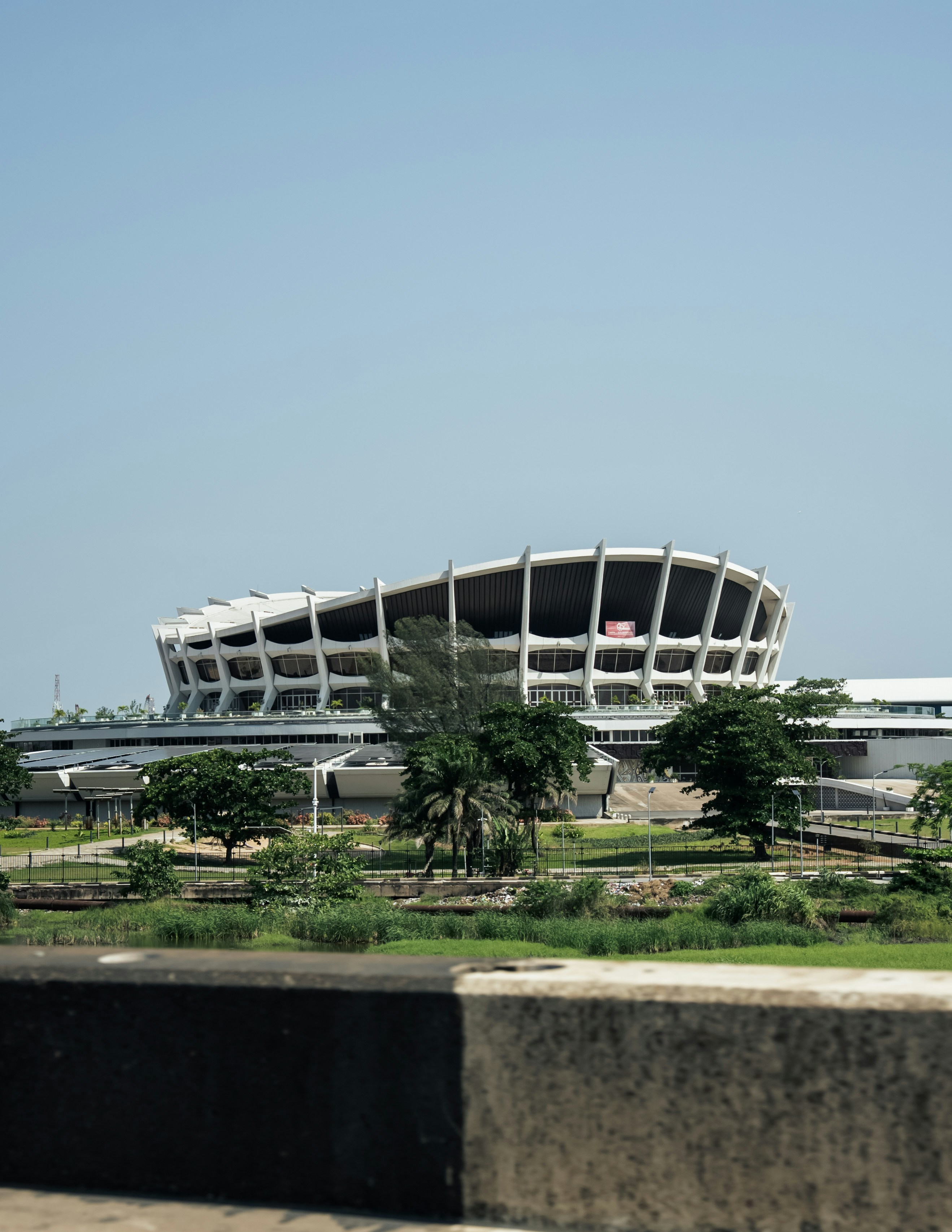 Stadium Silhouette Rising Above a Parked Riverside Walk