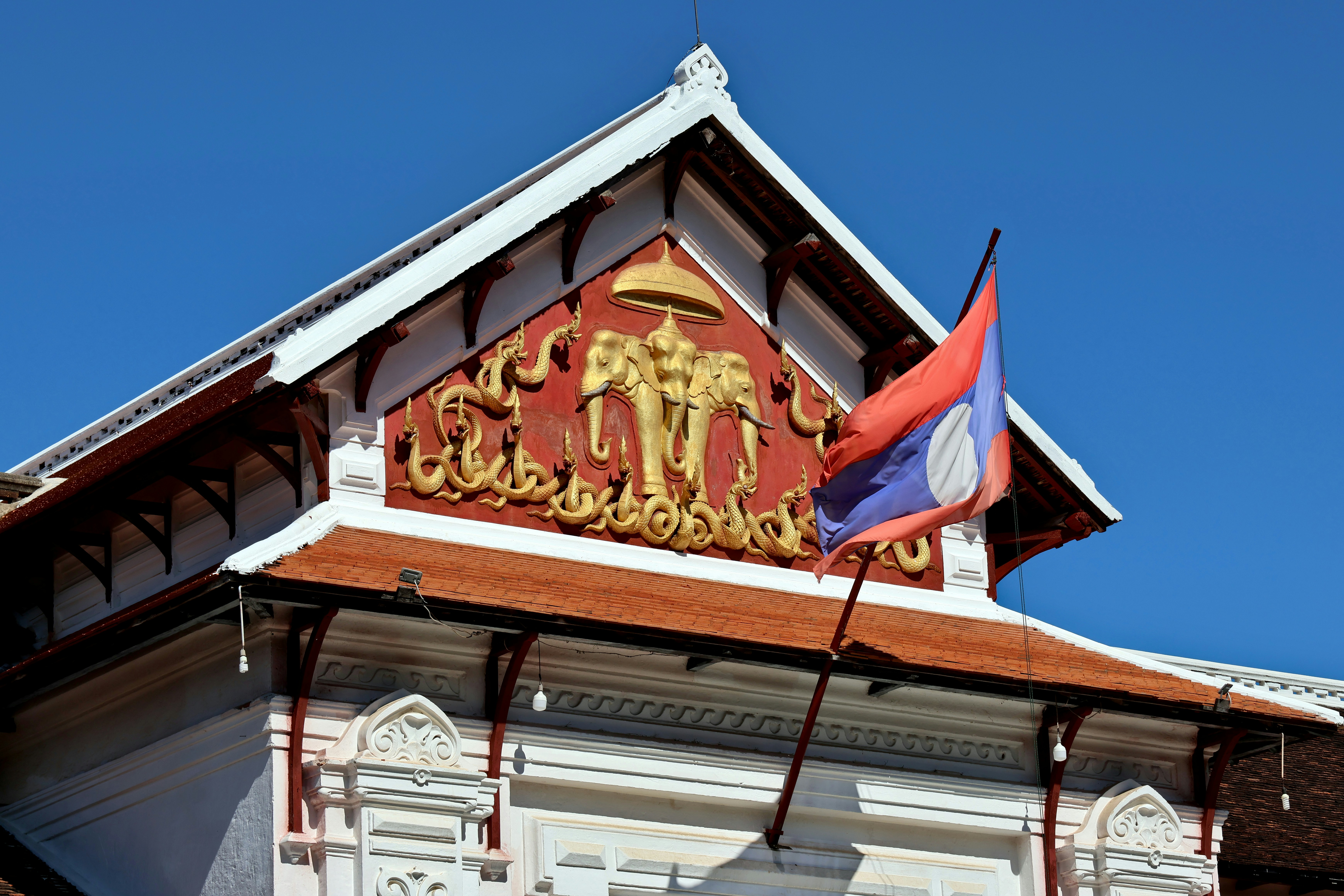 Ornate Roof Crest and Flag over a Historic Facade