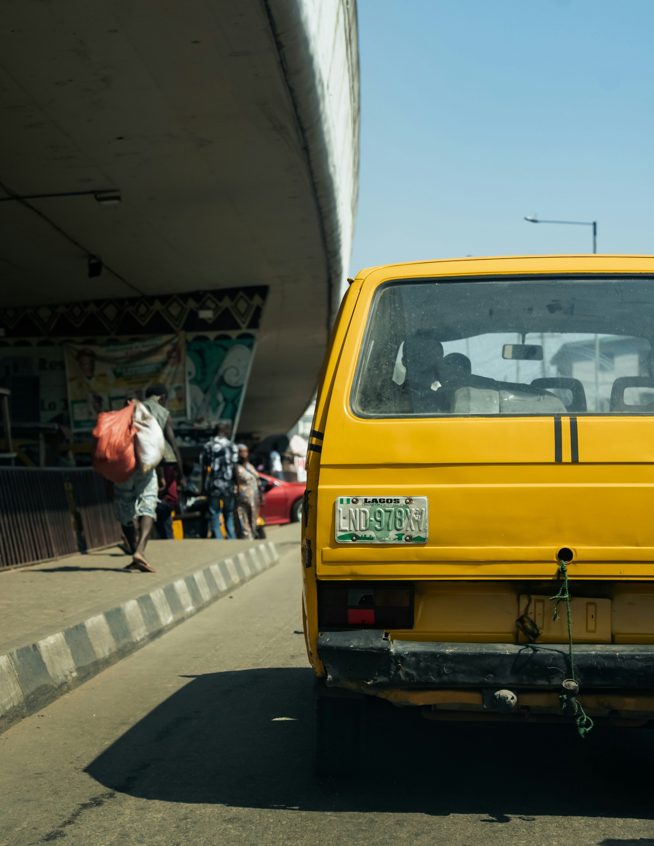 Yellow Van at the Edge: A City Bus Stop Snapshot