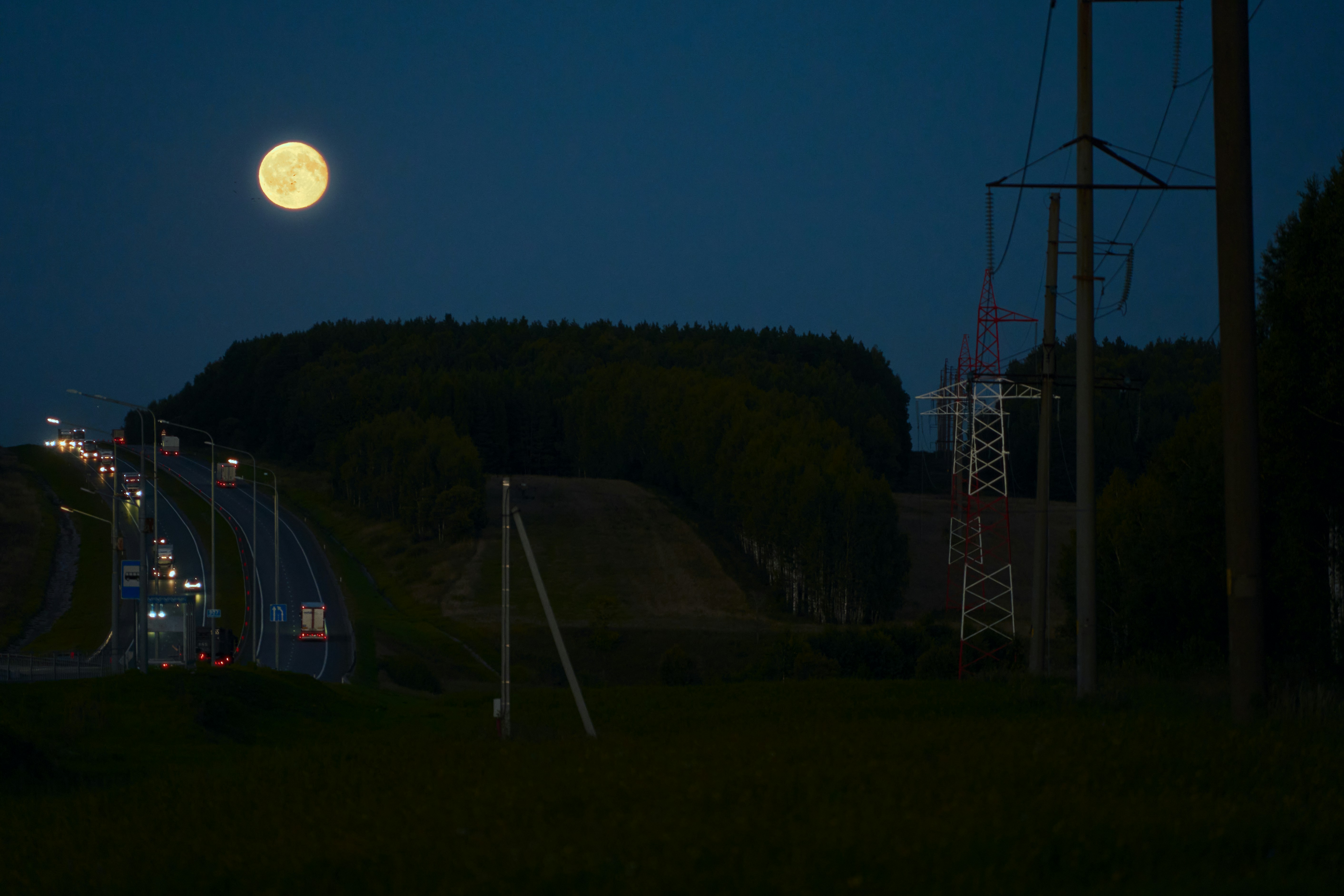 Lone Moon over a Quiet Rail Corridor at Dusk