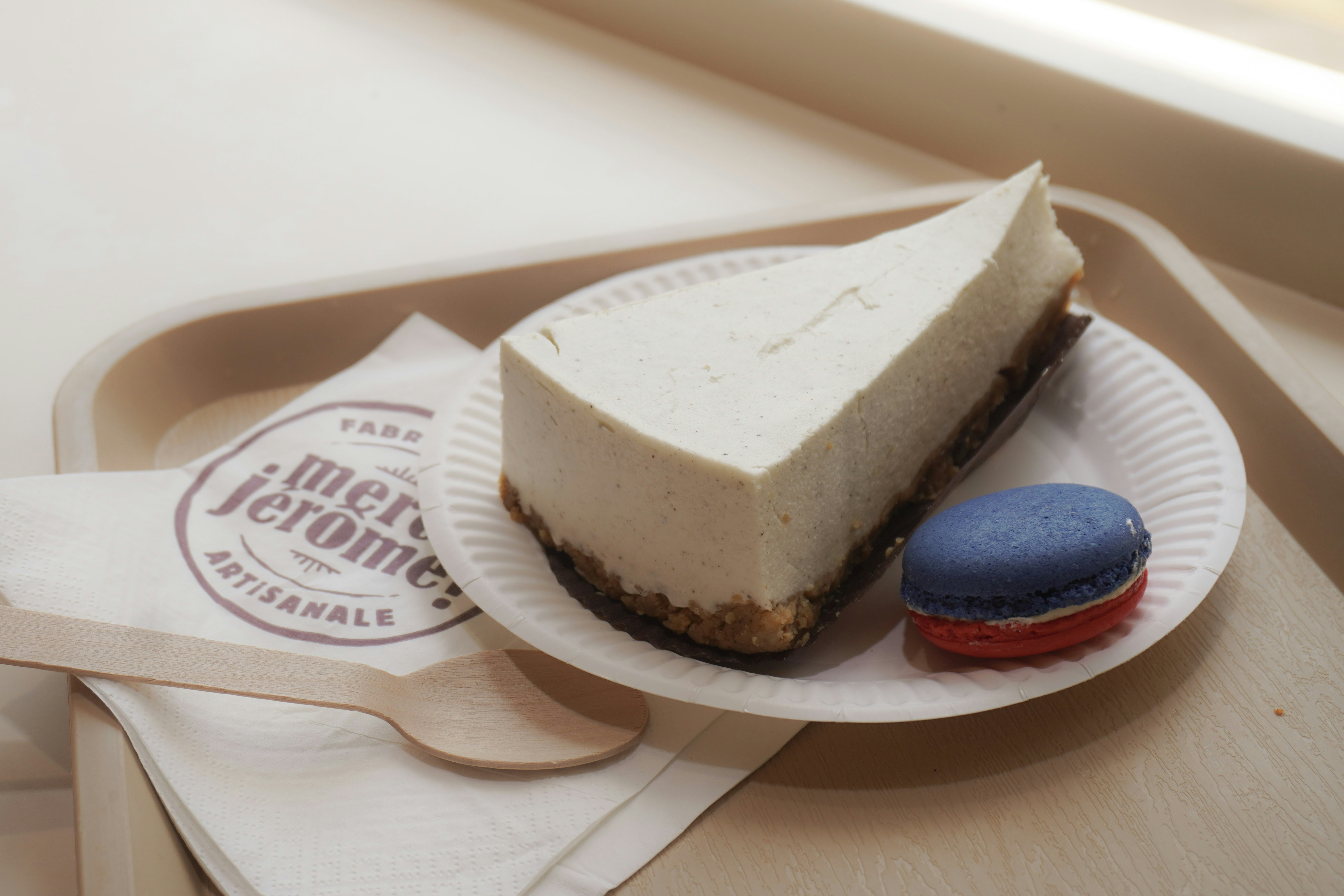 A Slice of Quiet: Cheesecake on a Tray with a Blue Macaron
