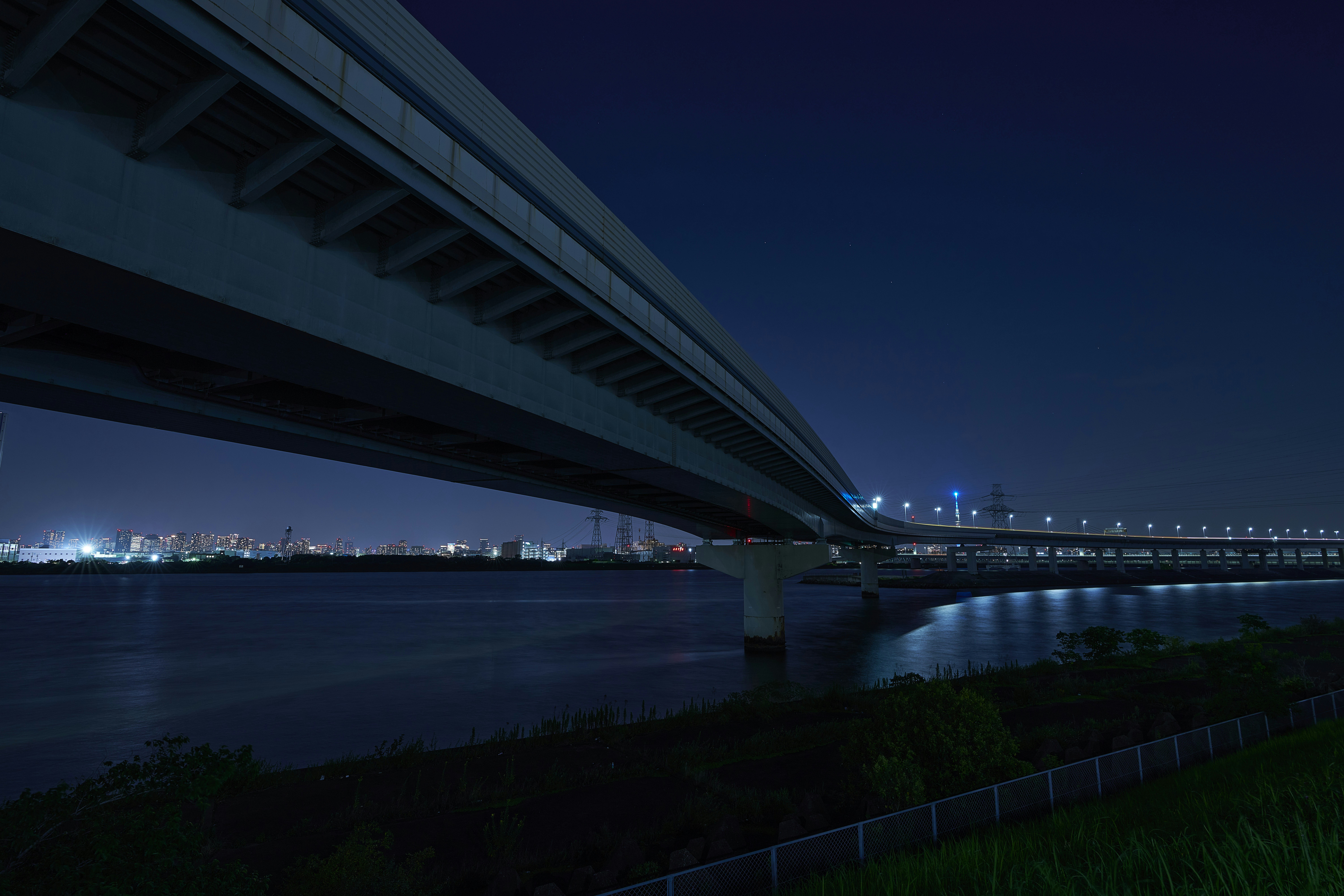 Underlit Arc: Nighttime Corridor of the River Bridge
