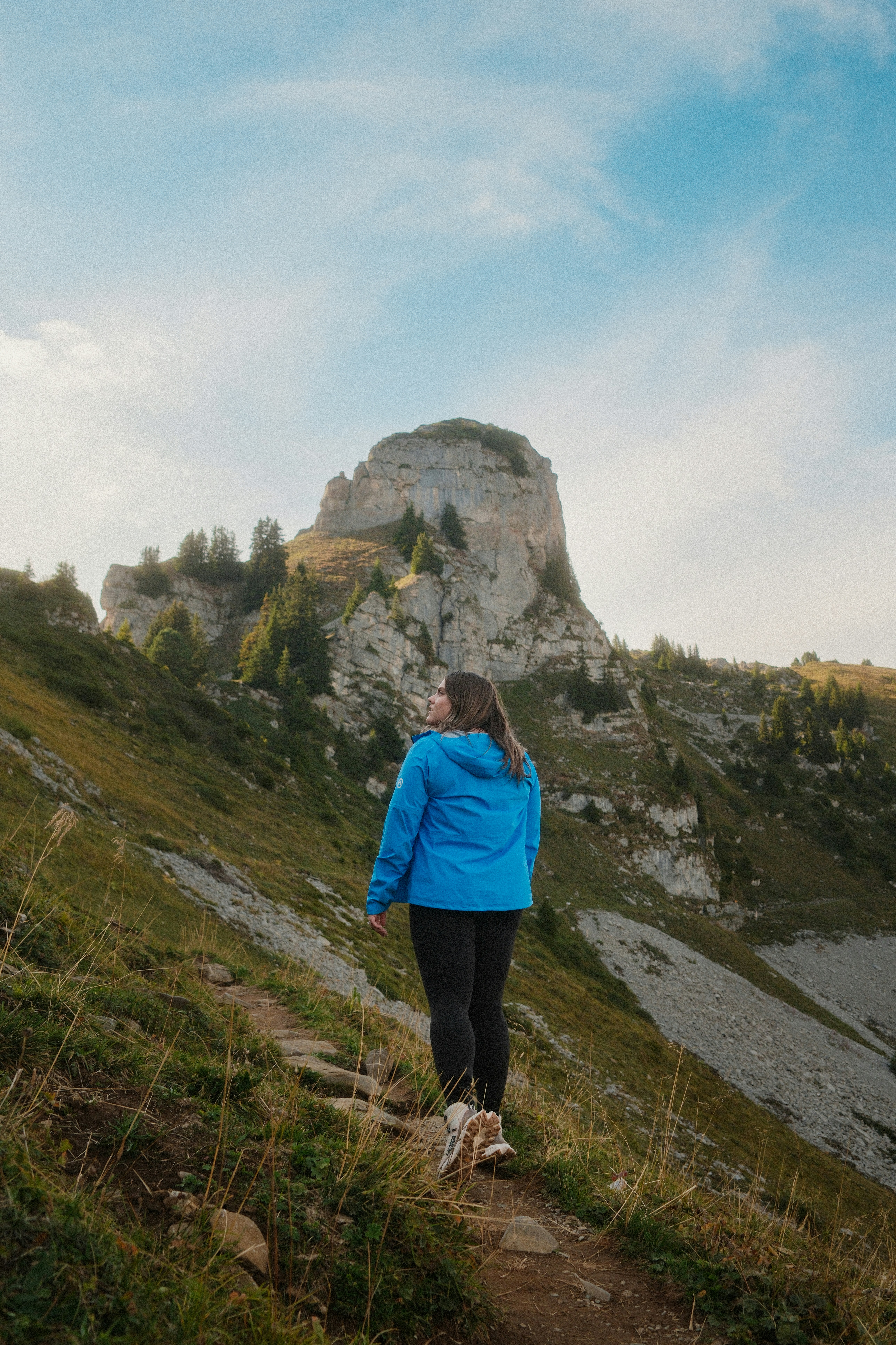 Blue Jacket Above the Ridge: A Hiker’s Pause at Distant Peaks