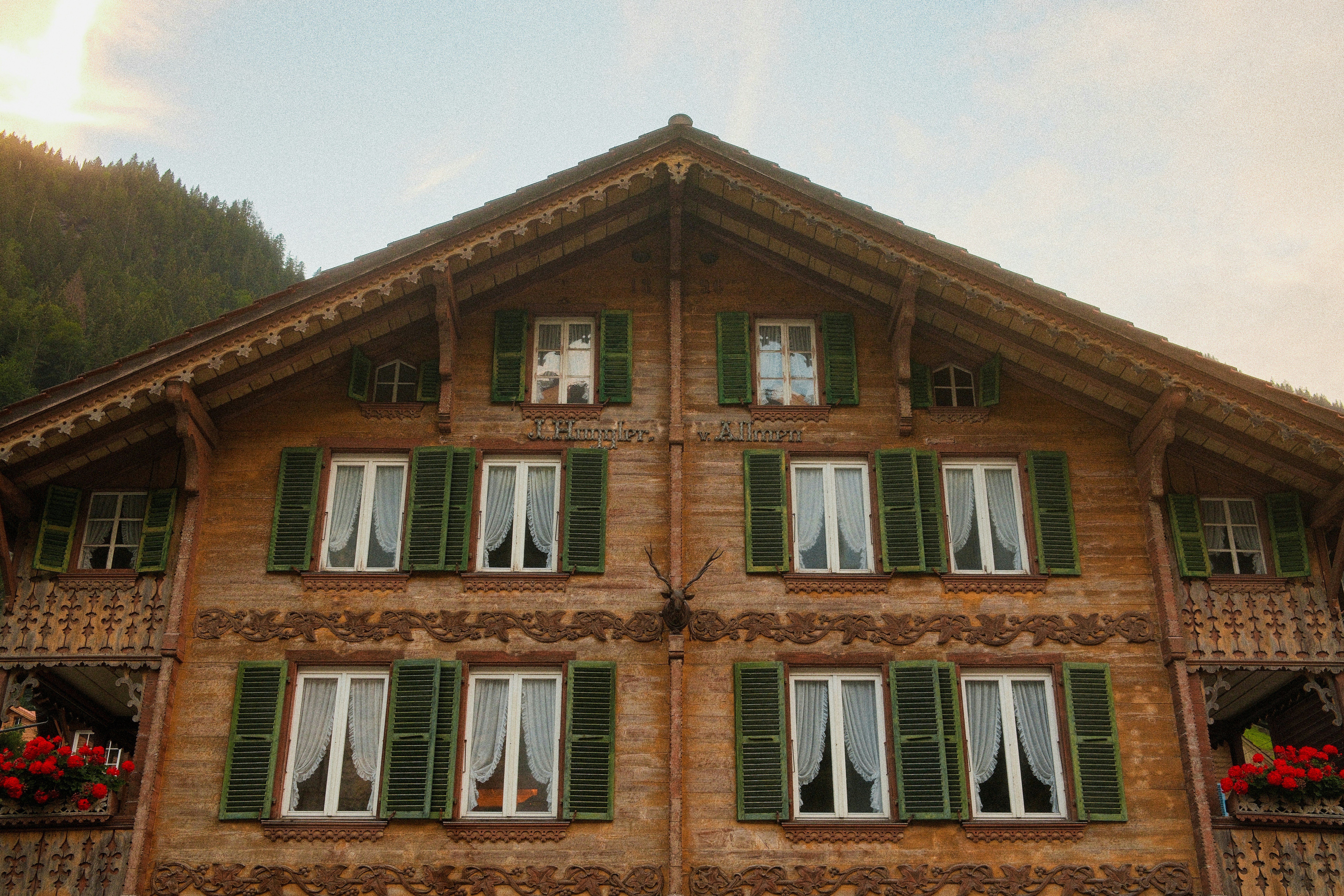 Mid-Century Chalet Facade: Green Shuttered Windows and Carved Balcony
