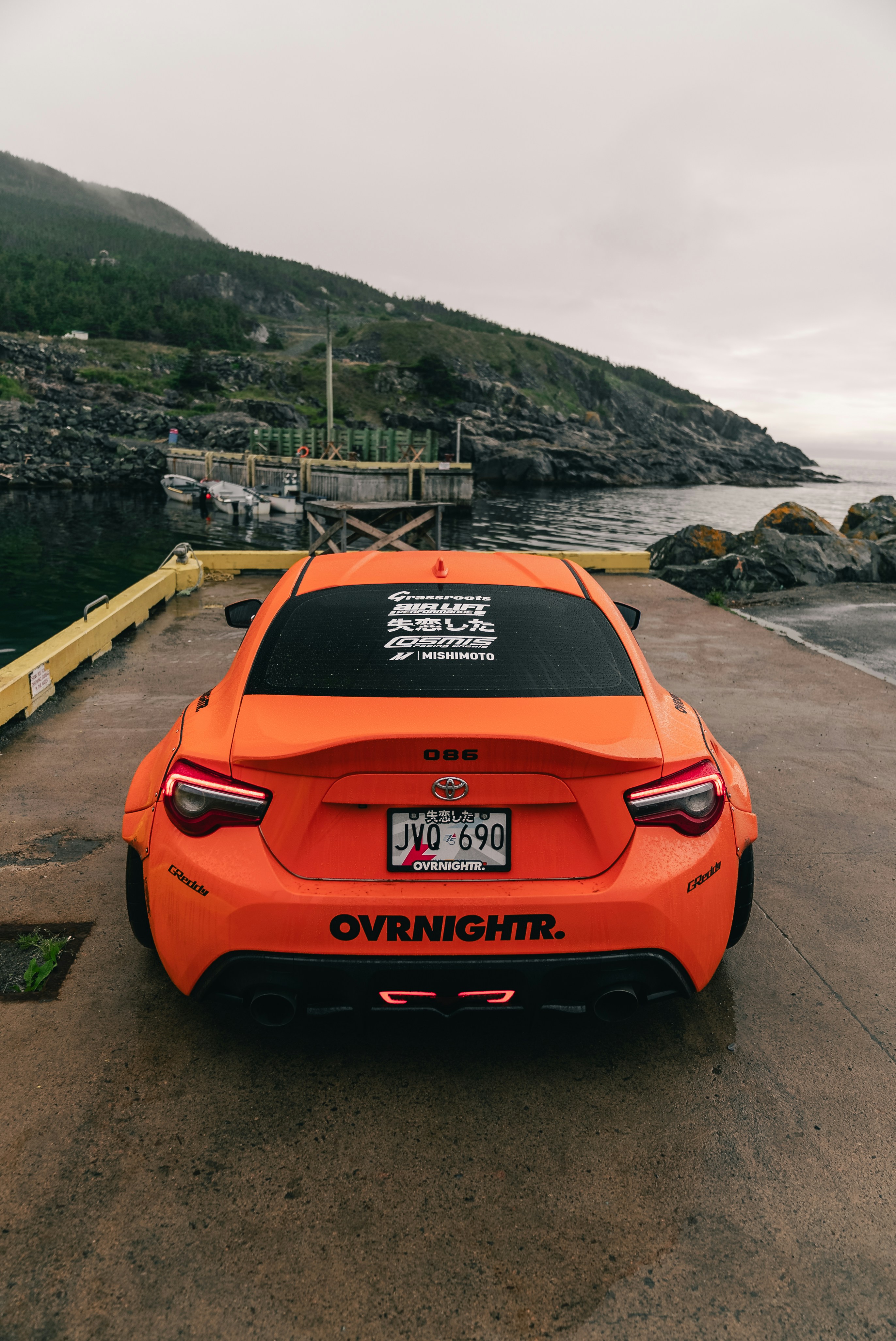 Orange Sports Car at the Pier: A Coastal Drive into the Horizon