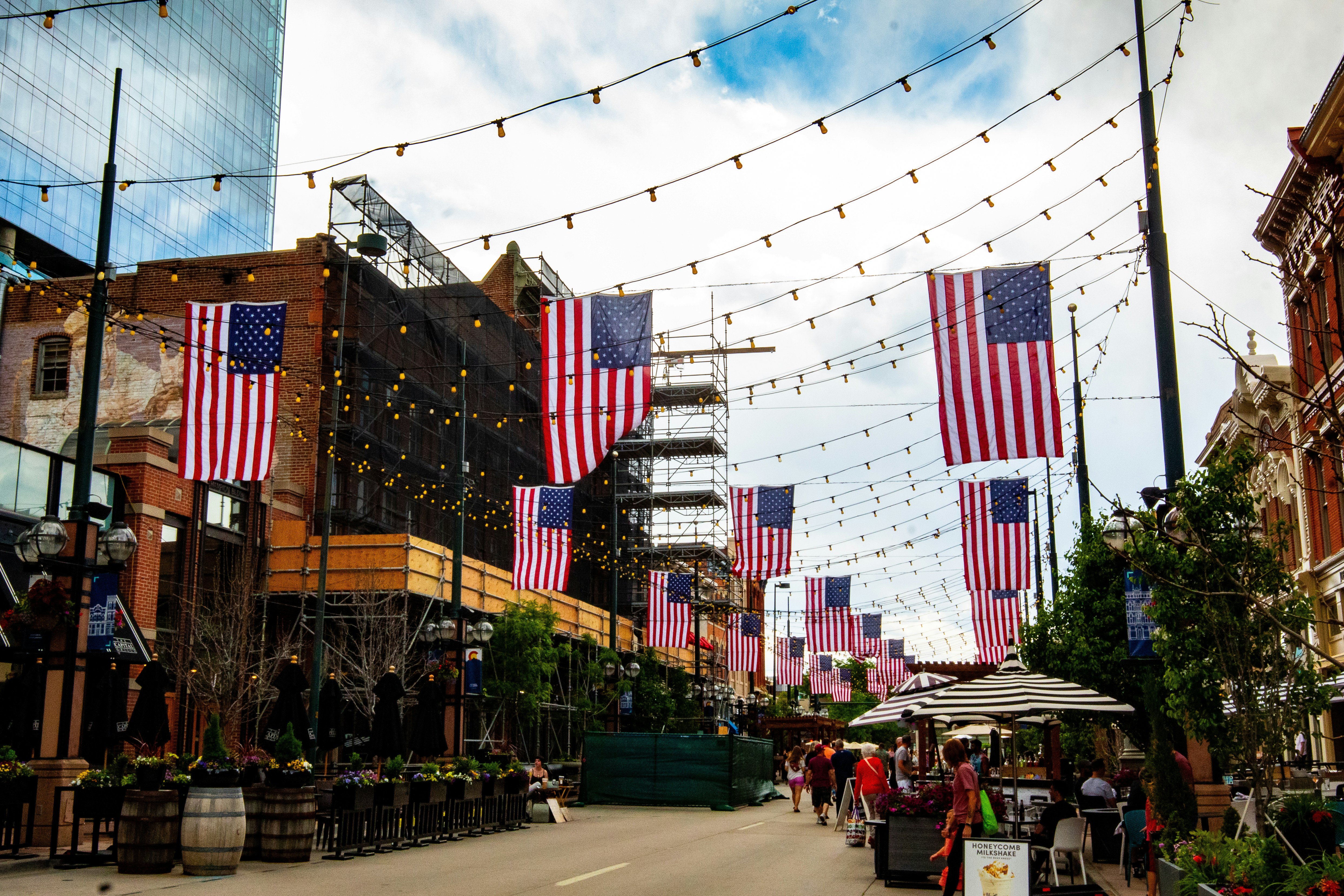 City Street of Flags: A Festive Day Under Strings of Lights