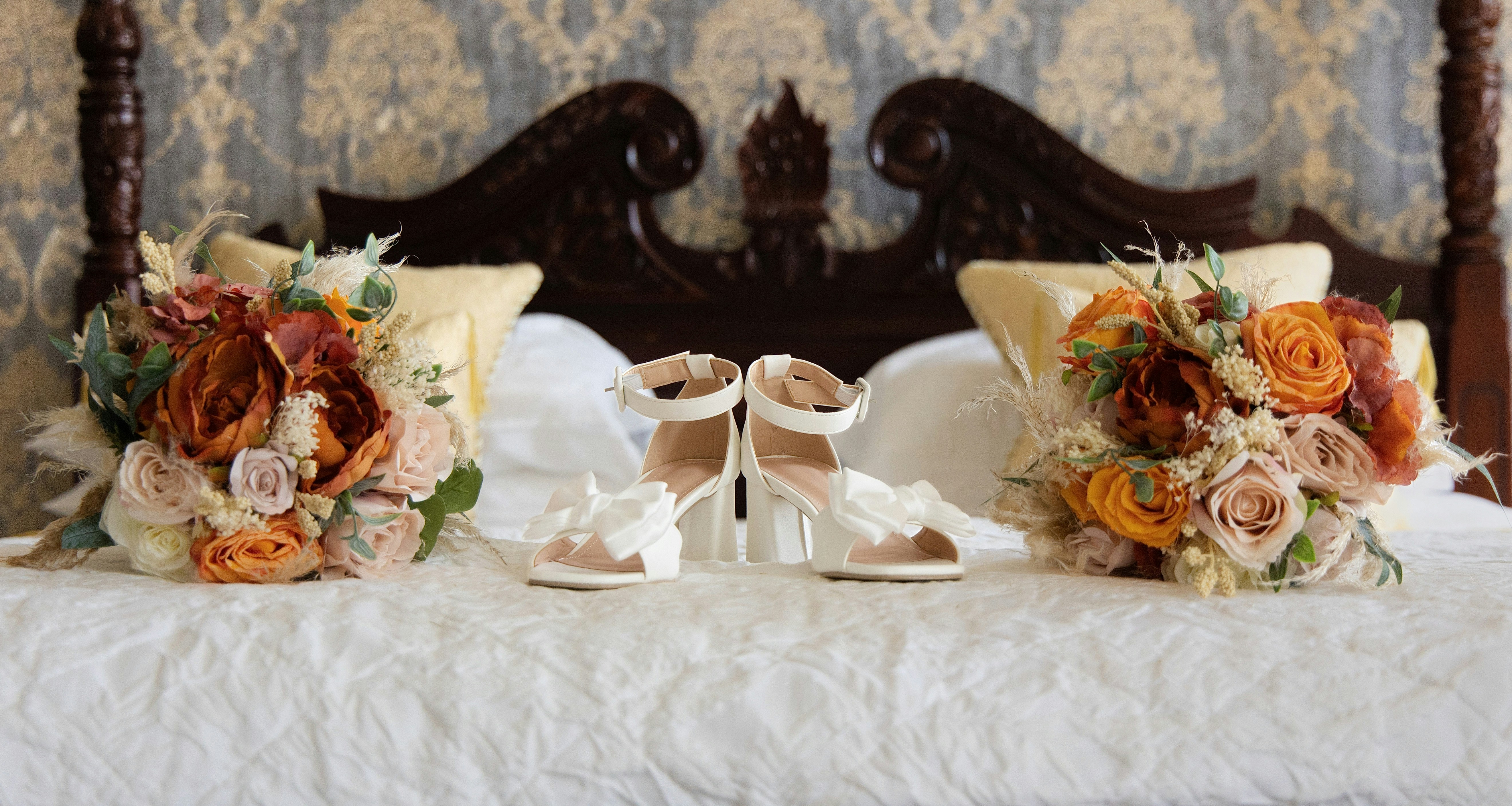 Wedding Bouquets Quietly Framed with Strappy Shoes on the Bed