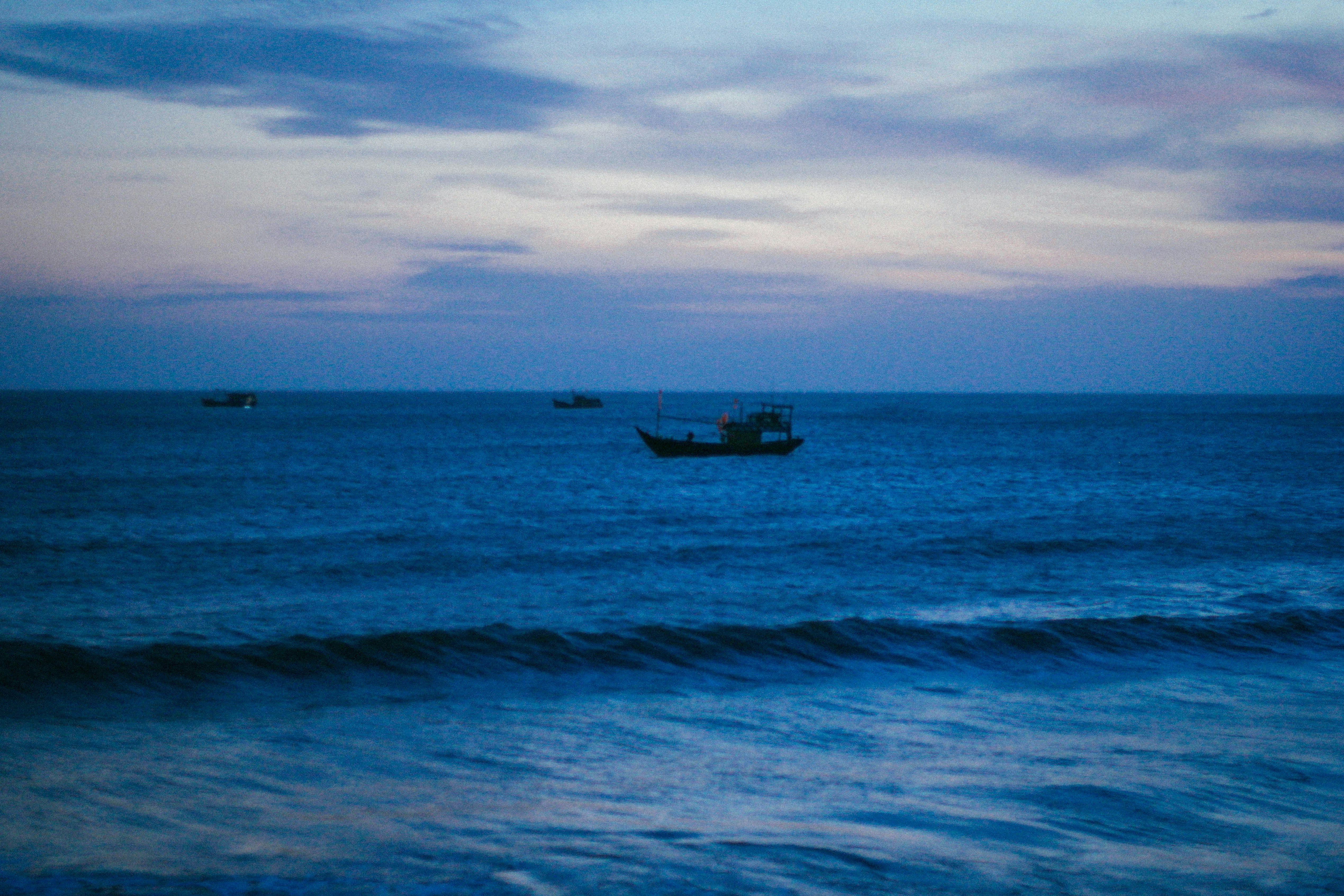 Midday Vessel: A Lone Boat Anchored Between Distant Horizons
